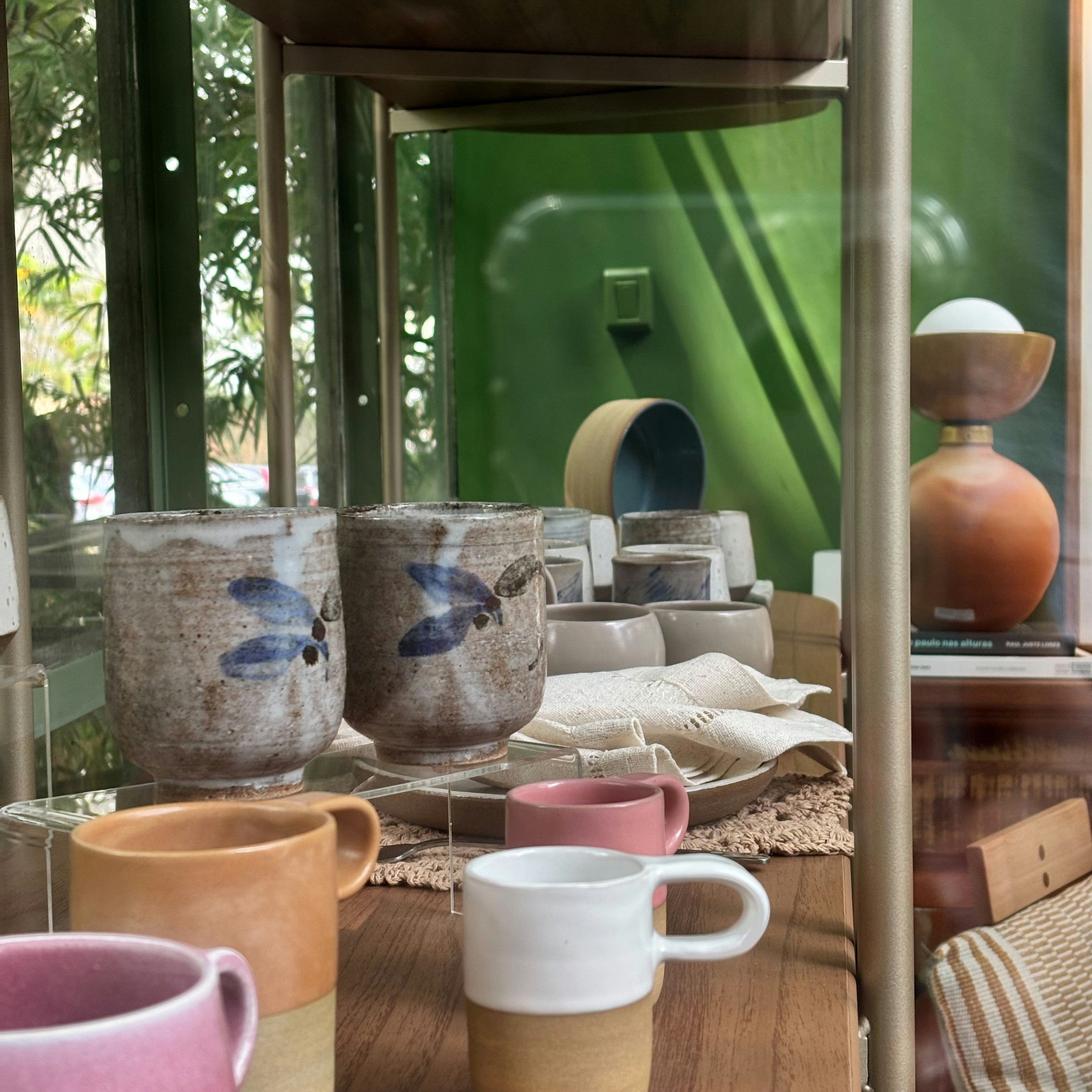 Ceramic Mugs and Tableware on Display in a Cozy Café Corner
