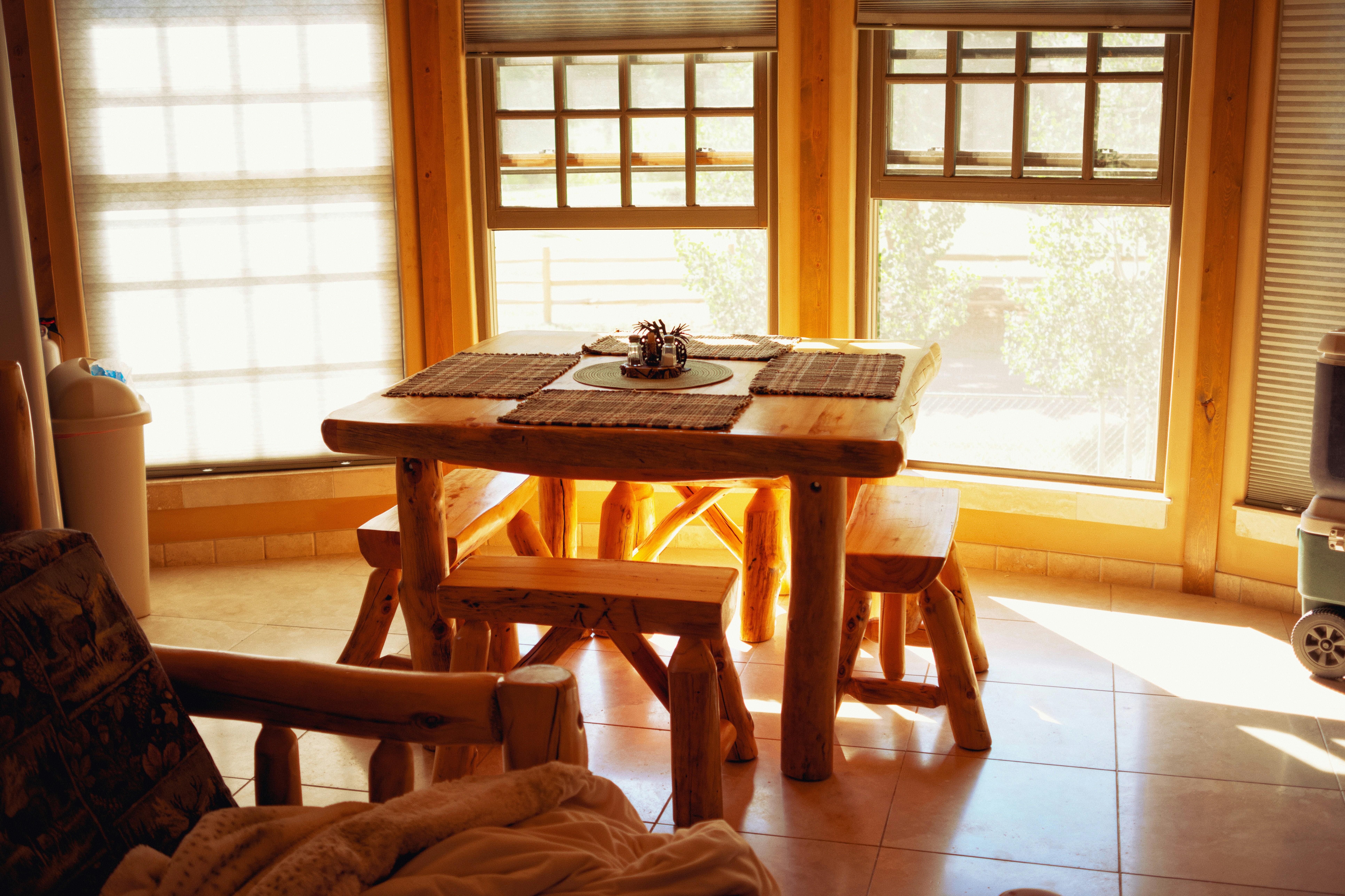 Sunlit Aspen Dining: A Cozy Wood Table by Large Windows