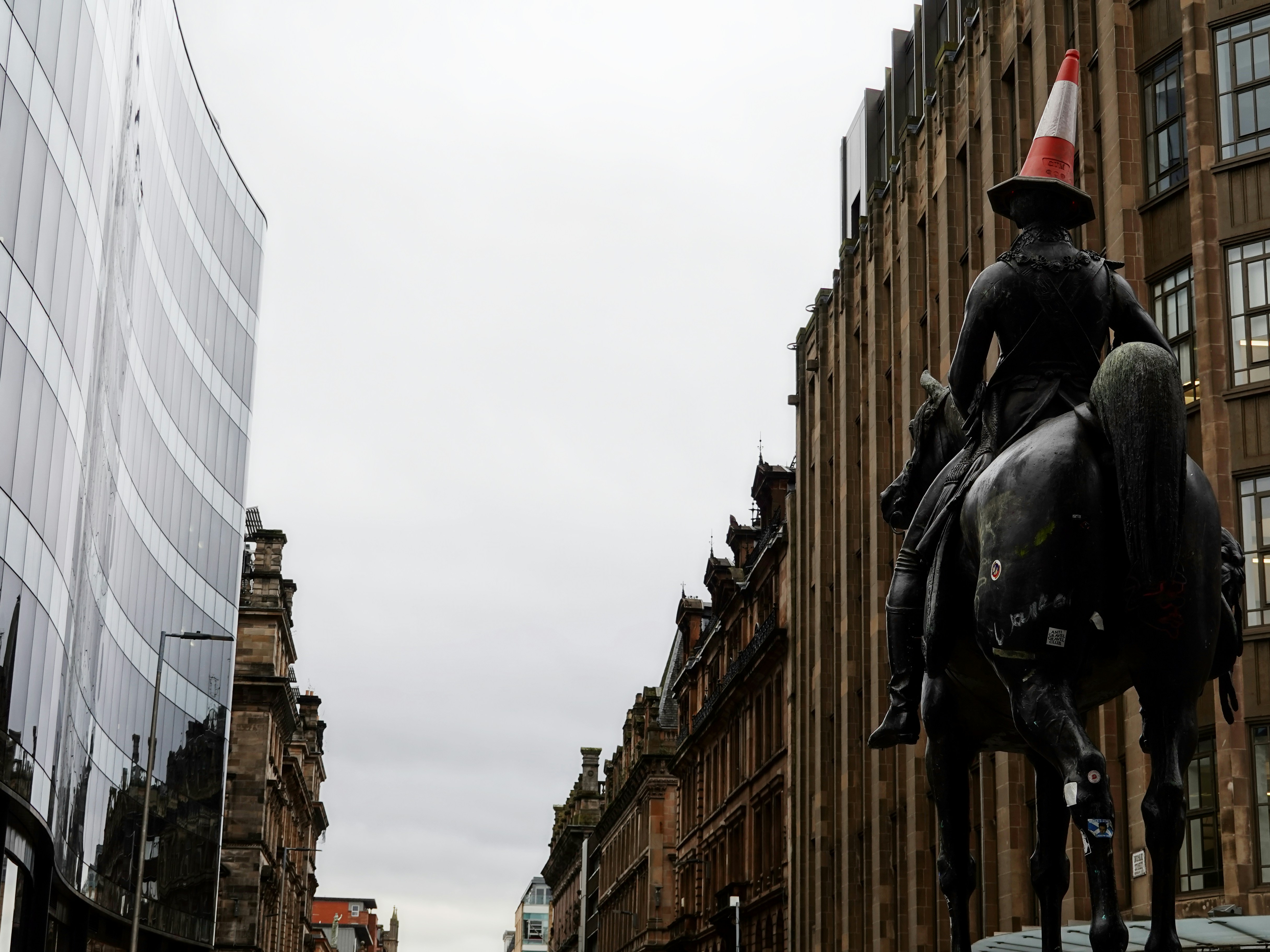 Traffic Cone Silhouette: A Mounted Rider Amid City Facades