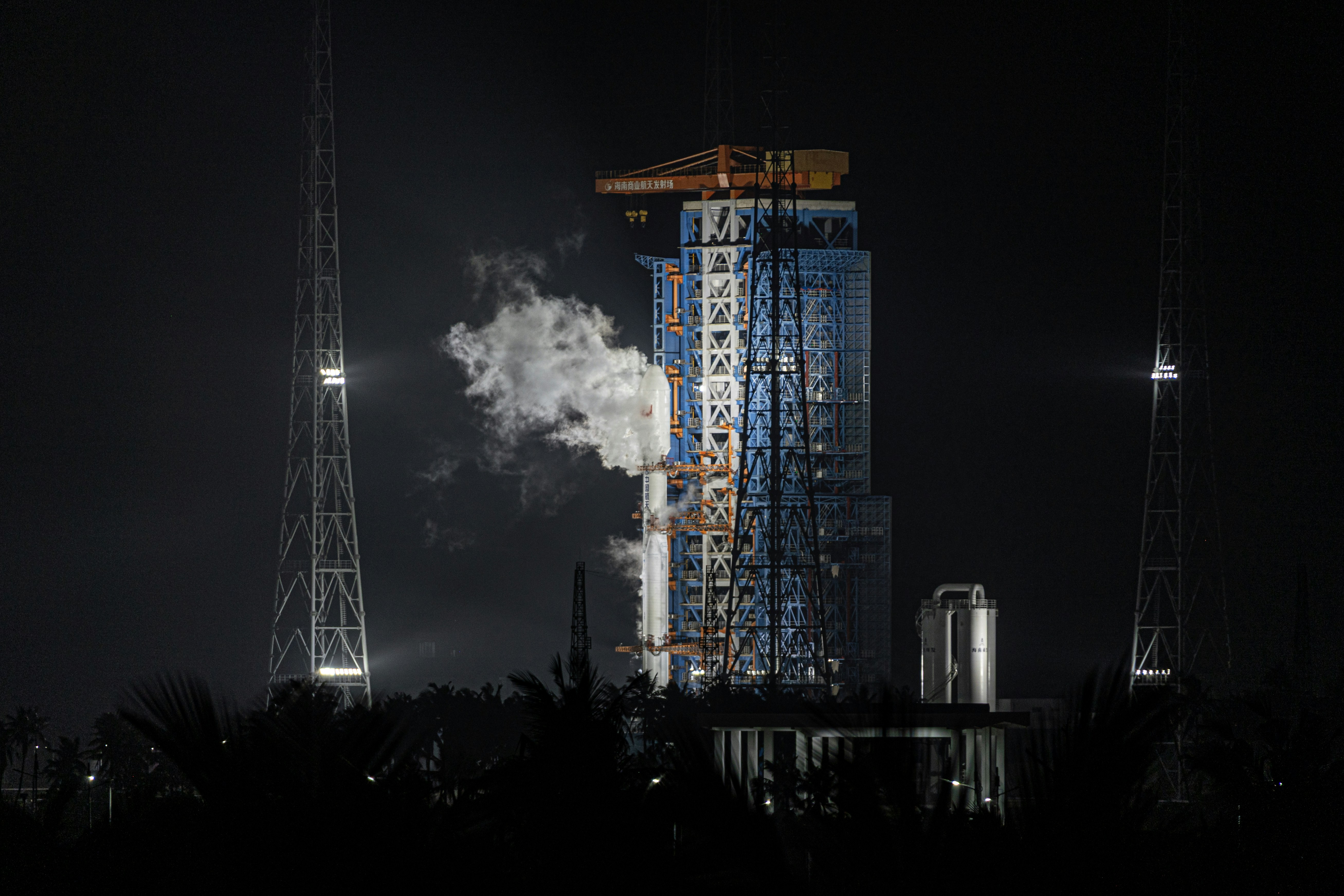 Liftoff in the Night: Launch Tower Silhouette and Rising Steam