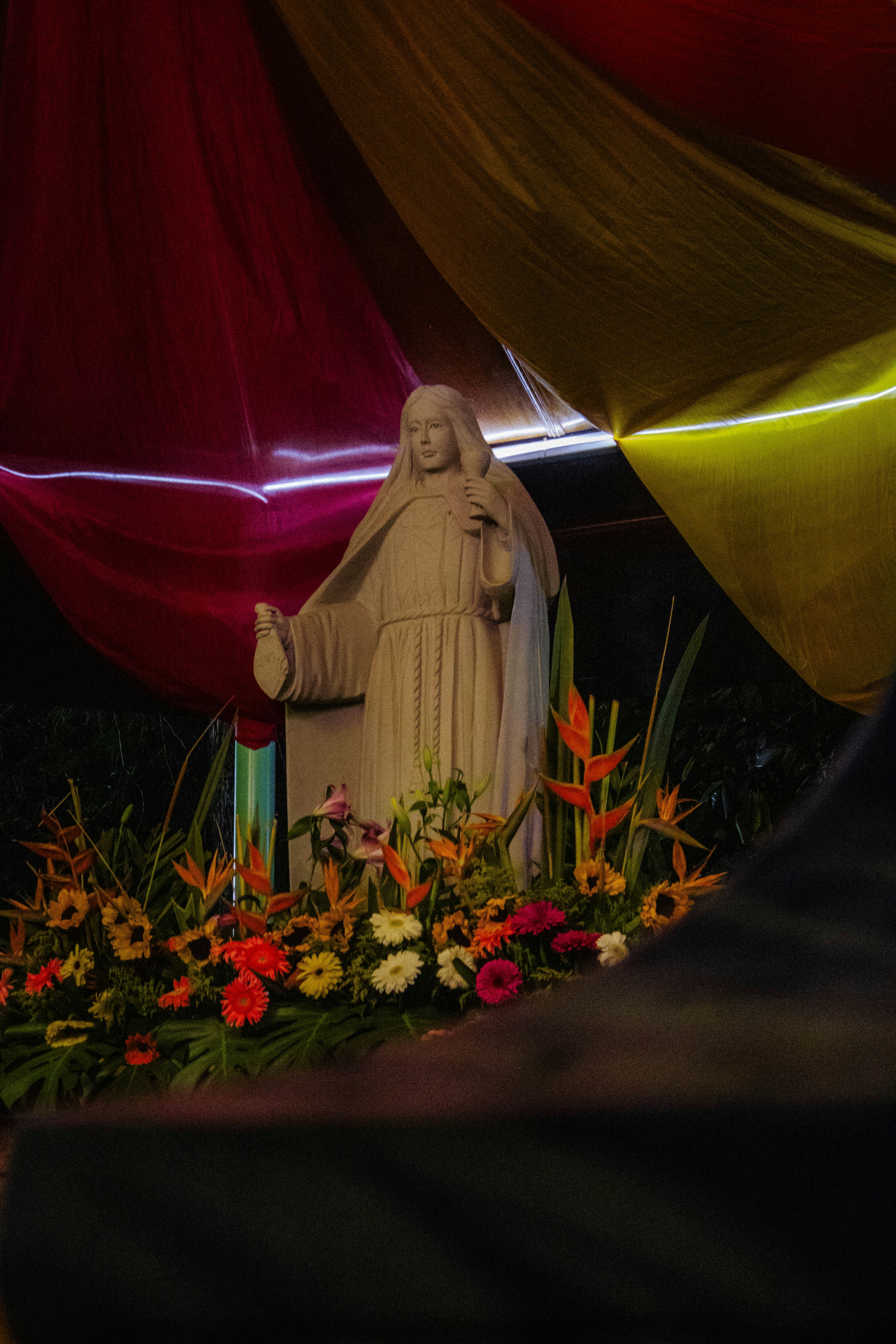 Statue of a Sacred Figure Adorned by Florescent Bannered Altar