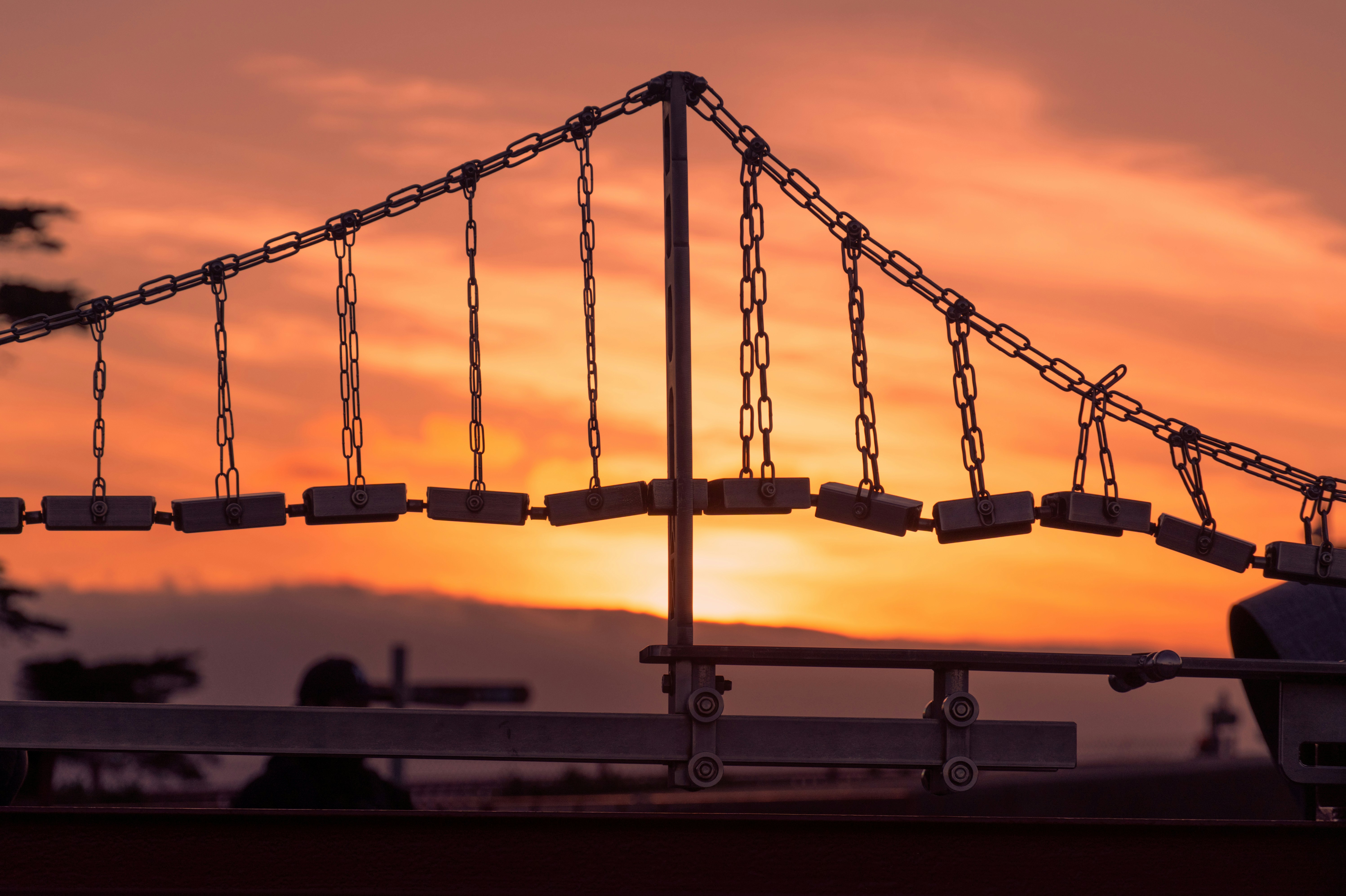 Evening Chains: Silhouette Playground Under a Fiery Sky