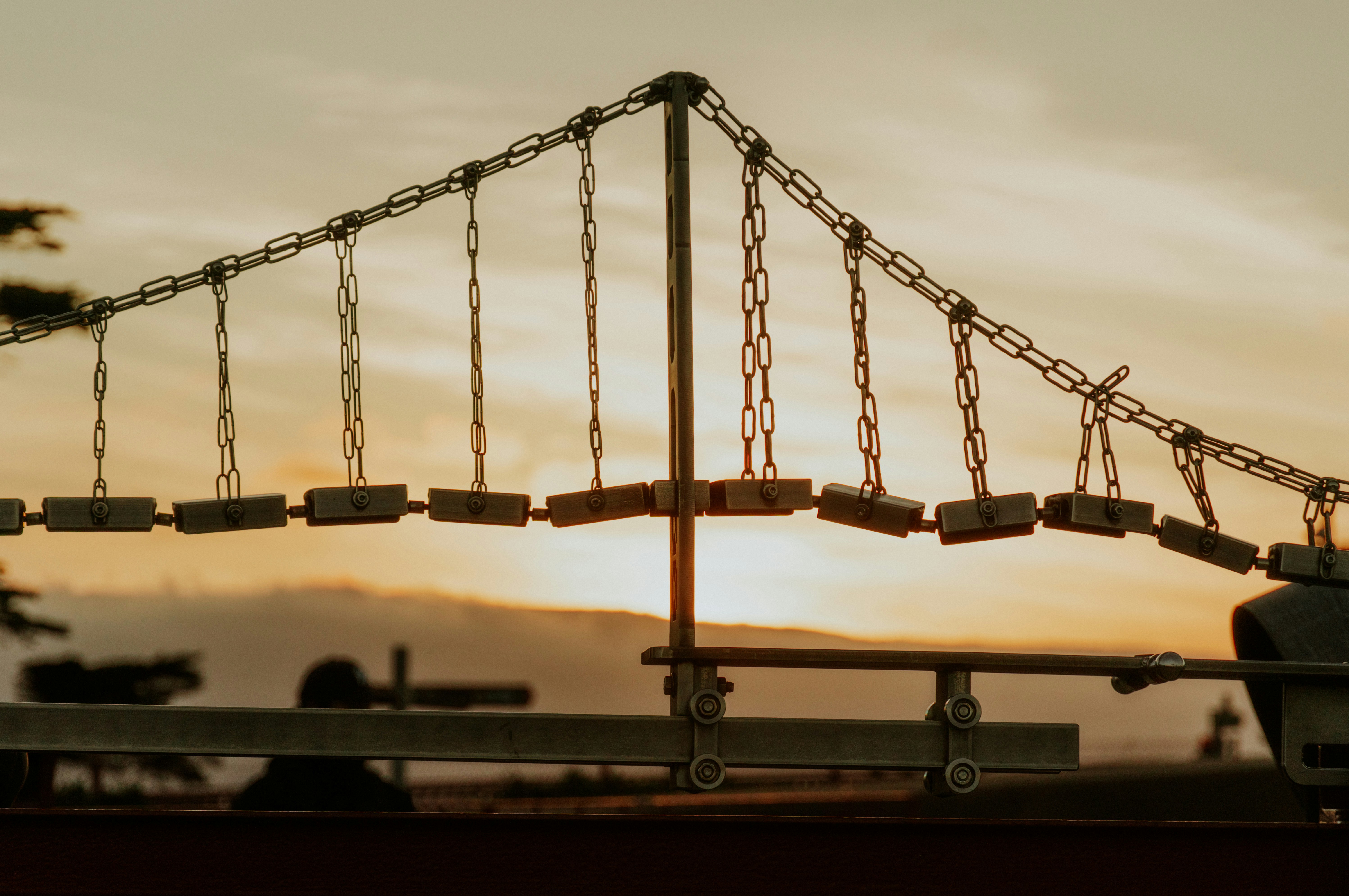 Silhouetted Suspension: Chains and Carriage at Dusk
