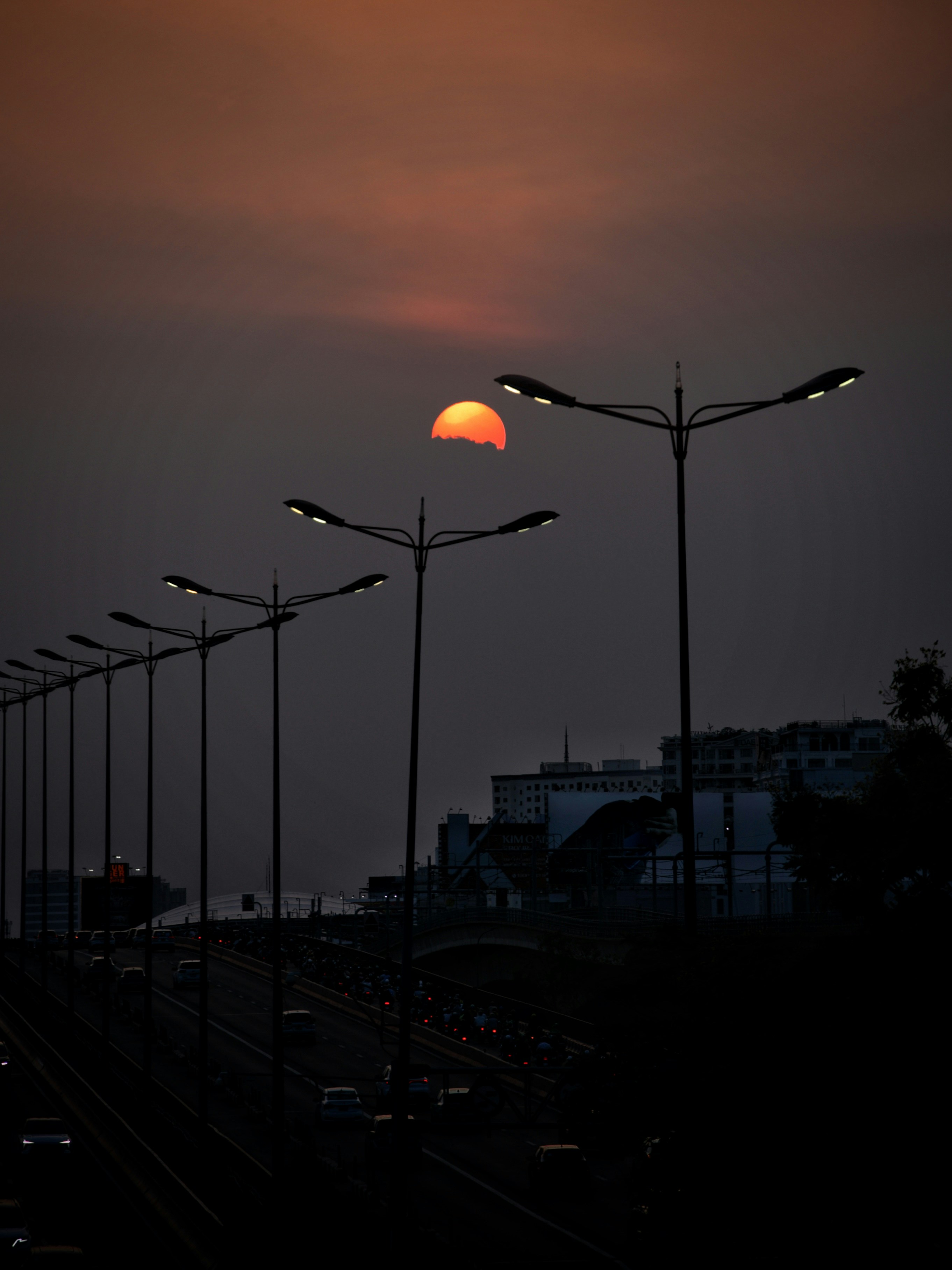 Sunset Sentinel: Street Lamps Align Over a City Horizon