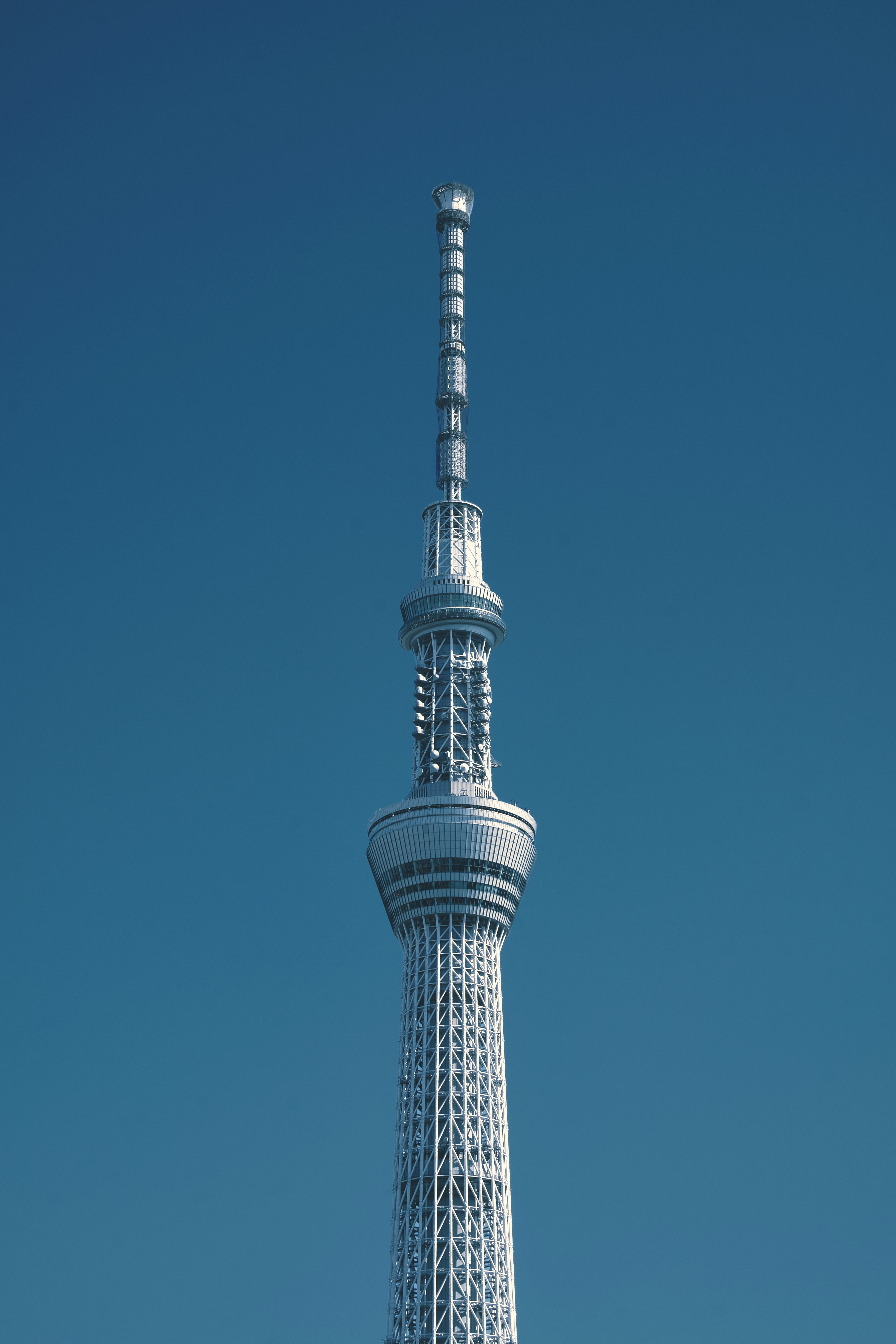 Tokyo Tower under a clear blue sky: vertical steel lattice reaching toward the heavens