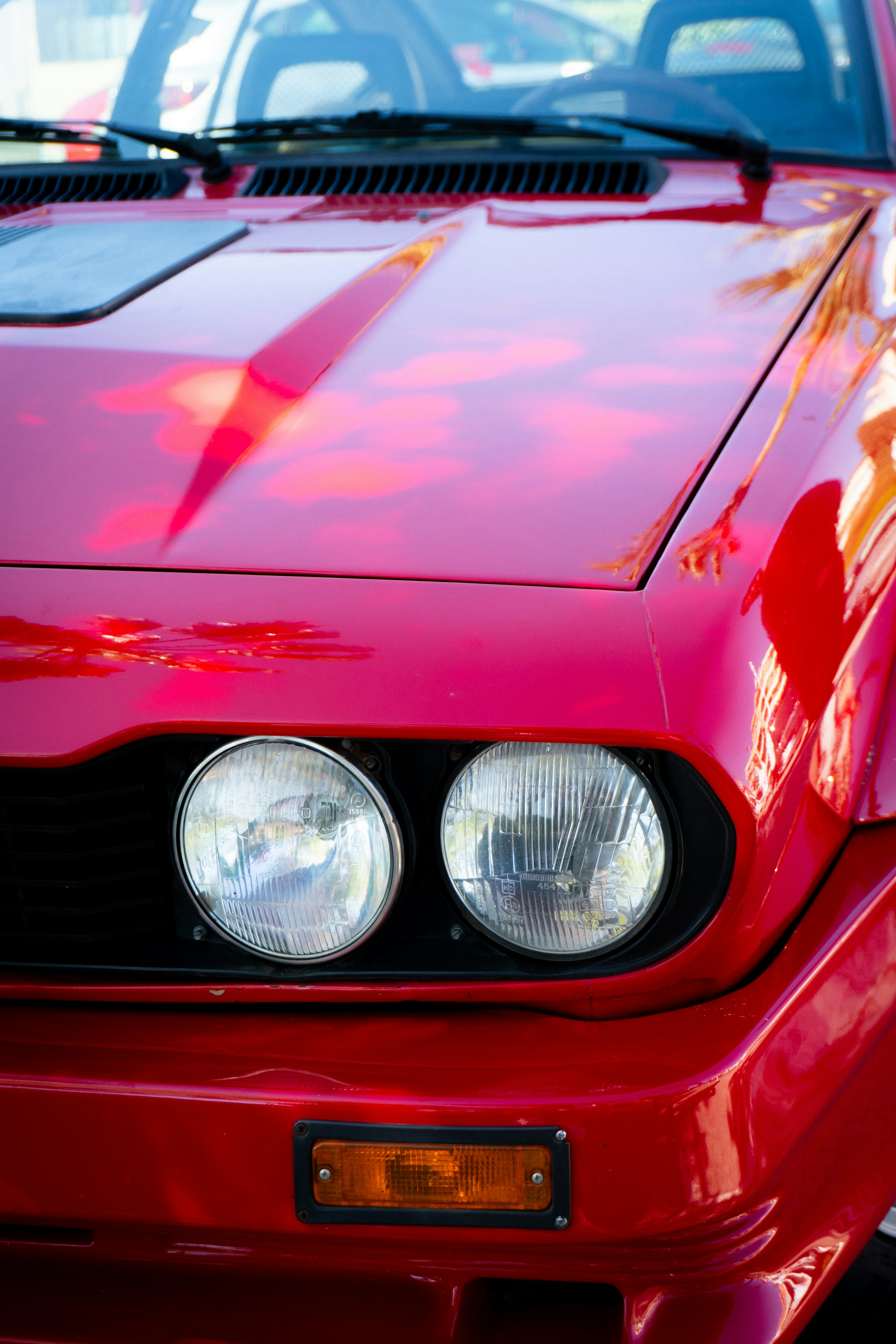 Red Classic Car Grille and Headlights, Close-Up Gleam