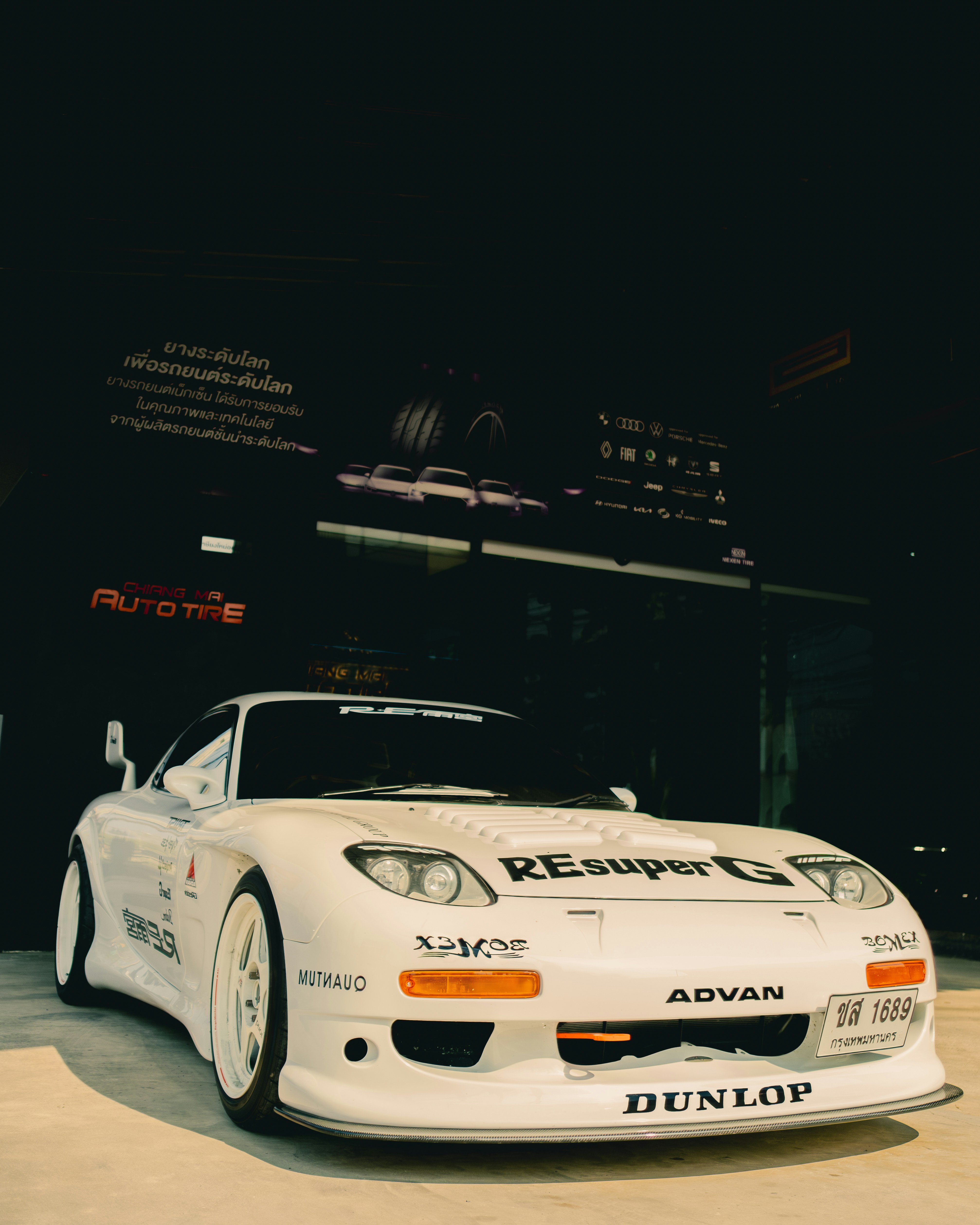 White race car under showroom lights: bold lines meet glossy silence