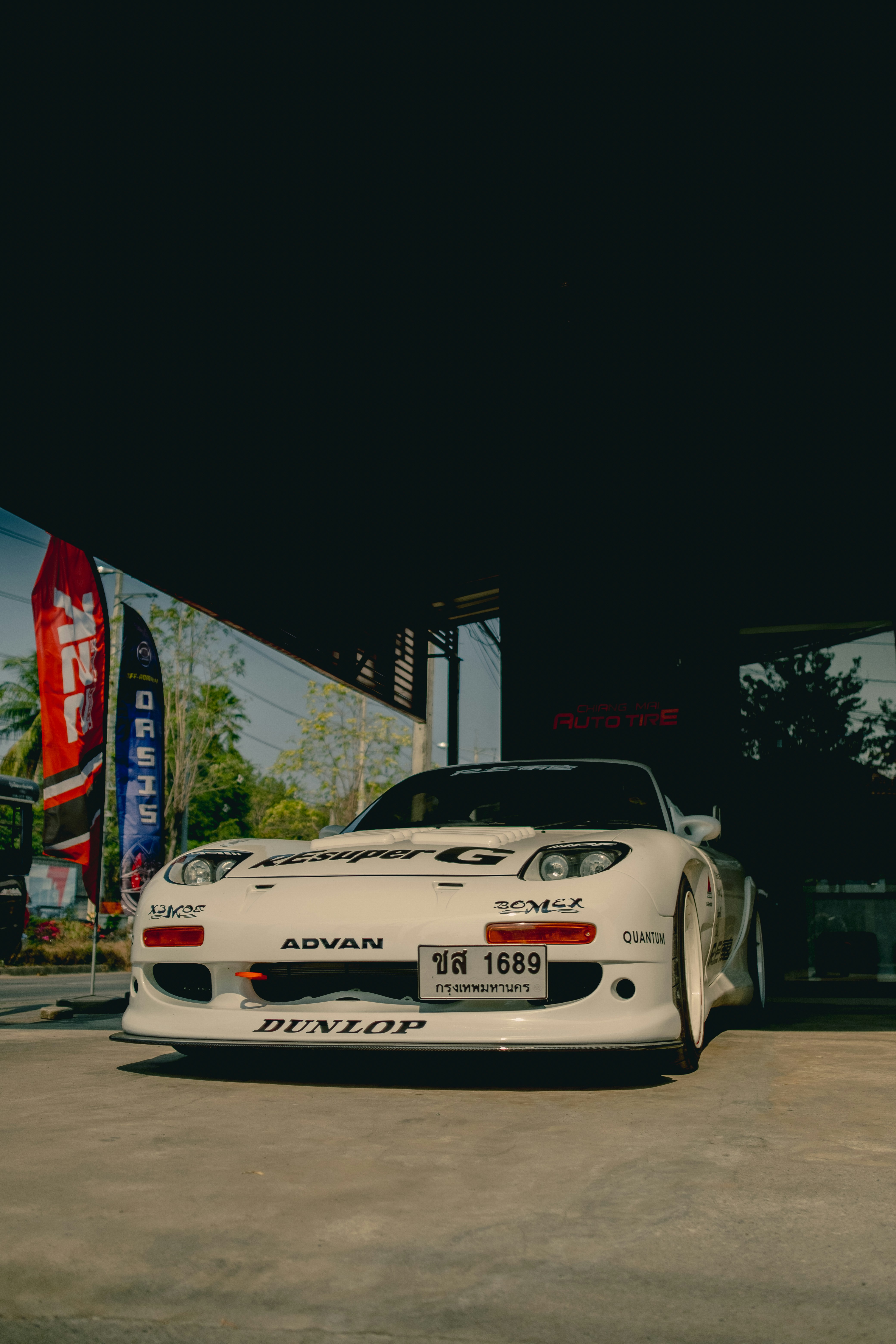 White race car under an open showroom canopy