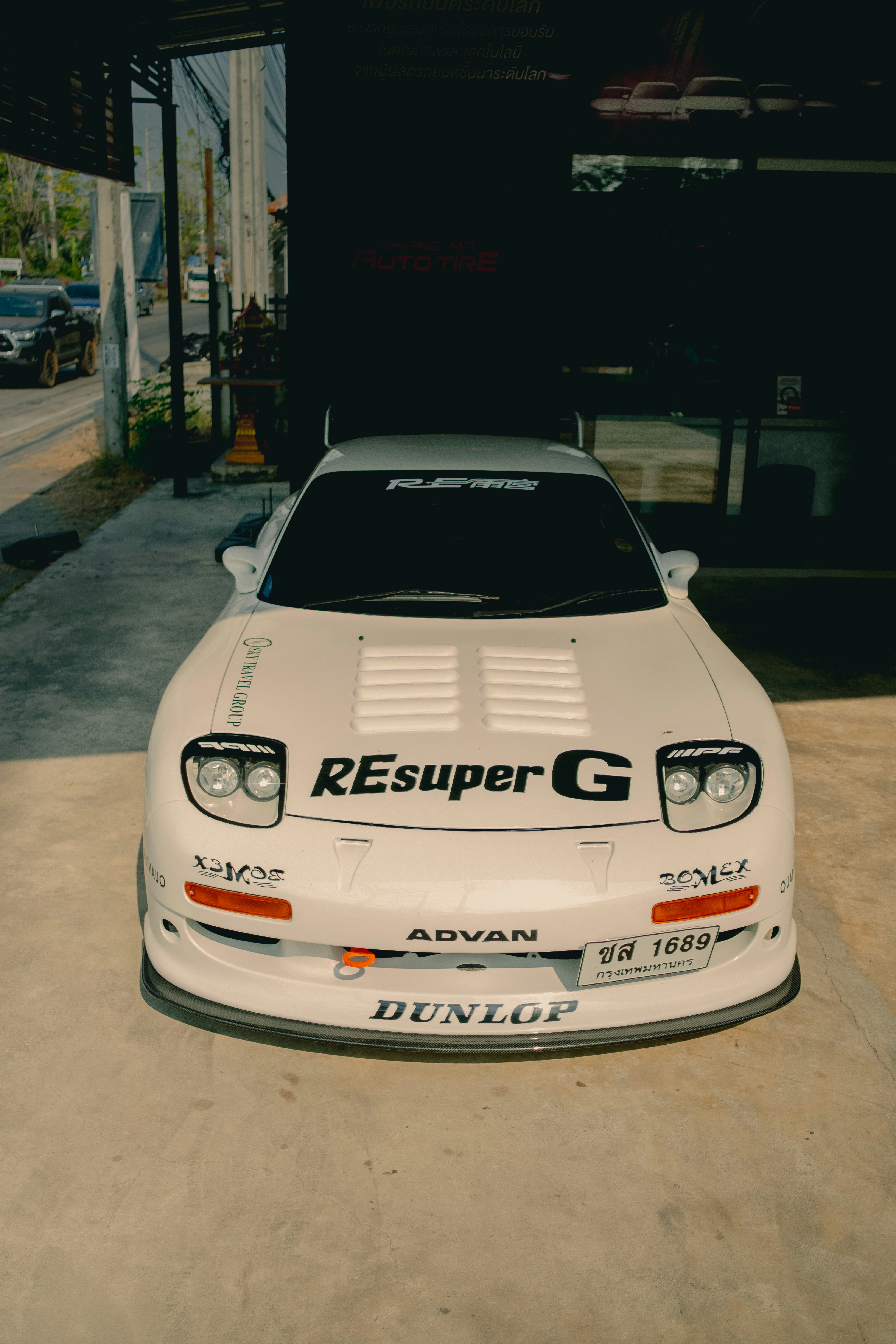 White race car in a dark showroom with bold 'RESuper G' branding