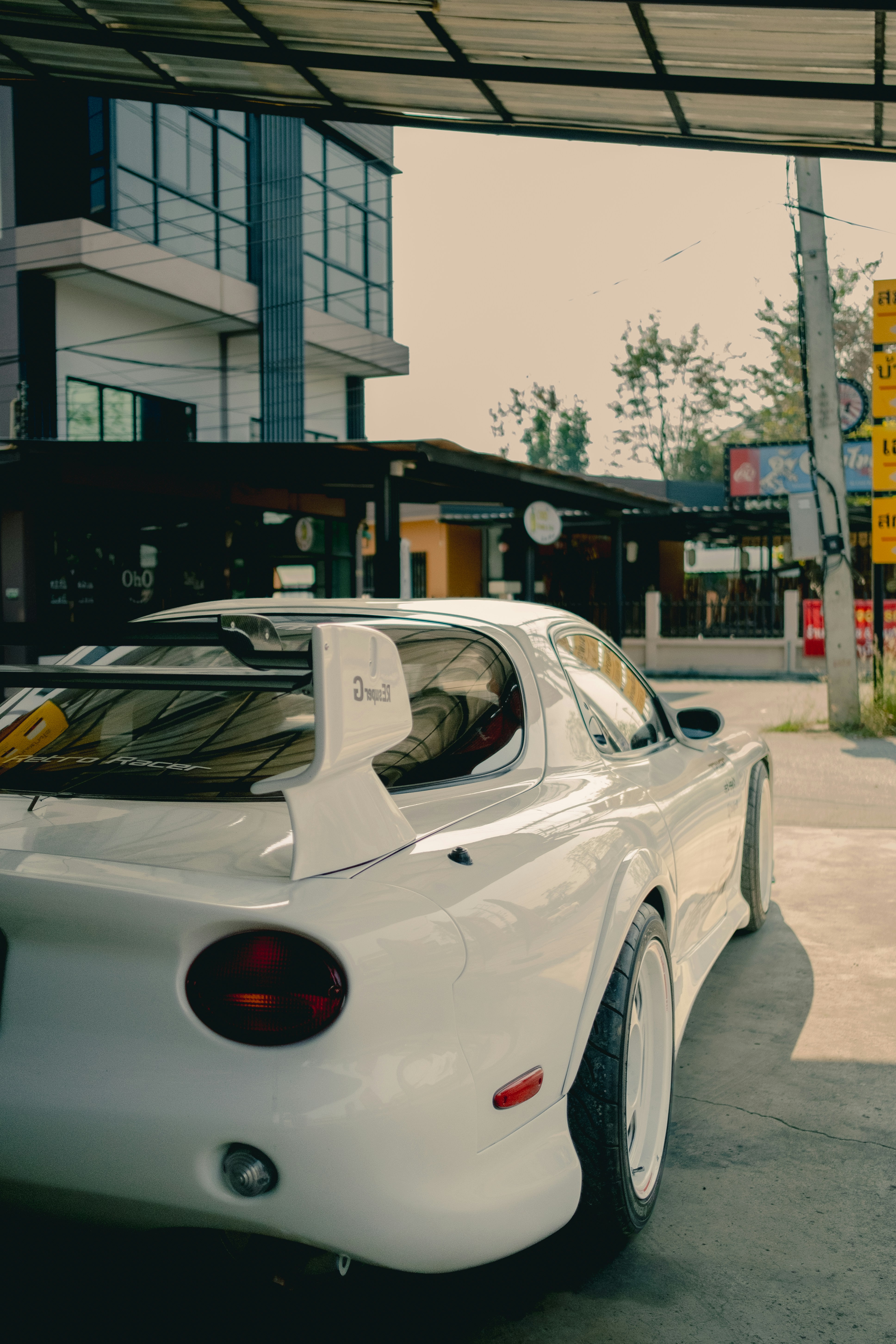 White GT Car Under a Canopy, Rear Quarter in Focus
