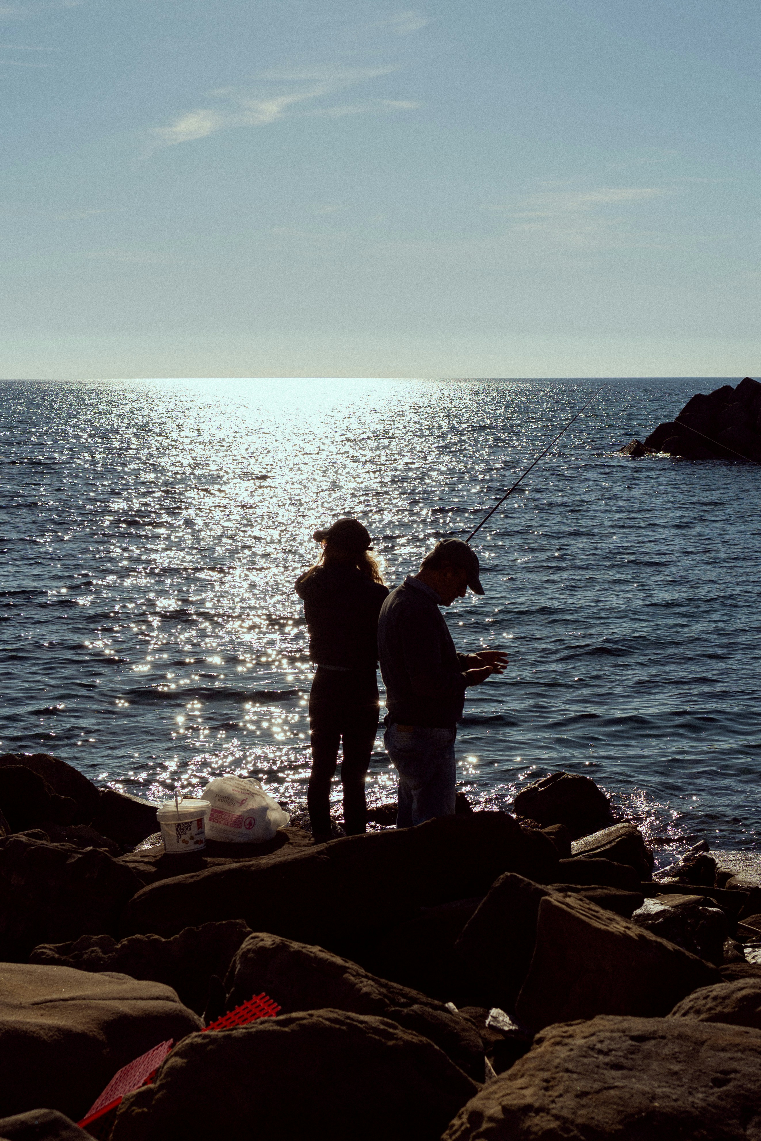 Sunlit Silhouette: Two Figures by the Sea