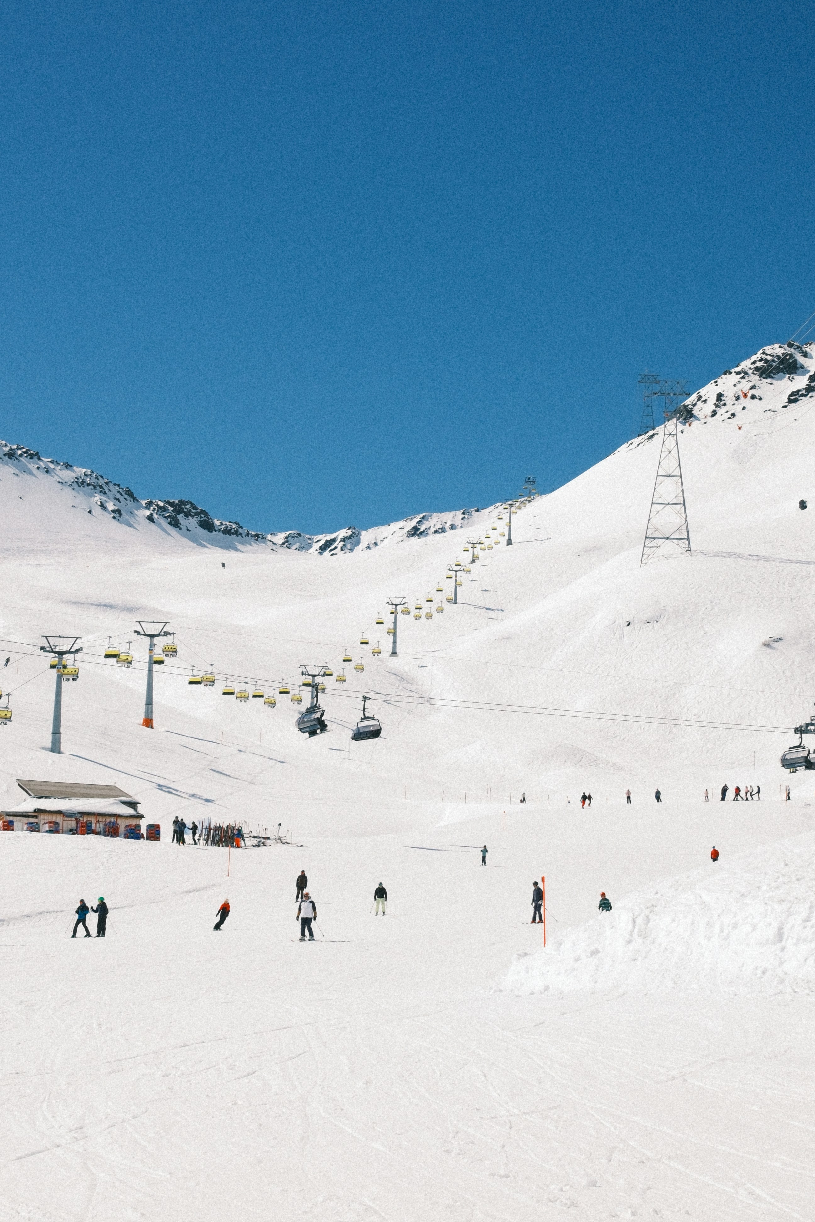 Chairs Ascend: A Quiet Slope Under Blue Sky