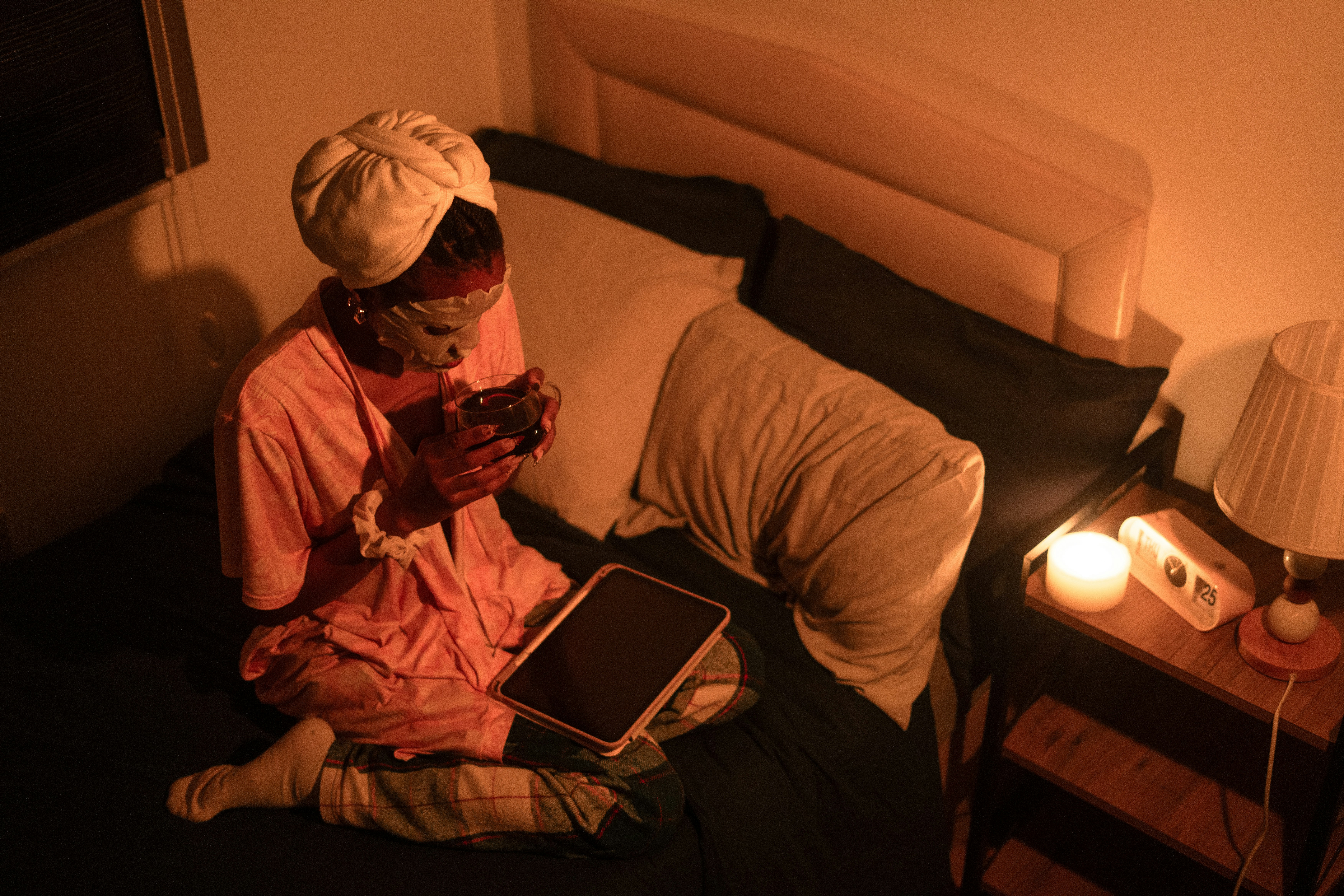 Midnight glow: a quiet moment with a tablet and phone in warm lamplight