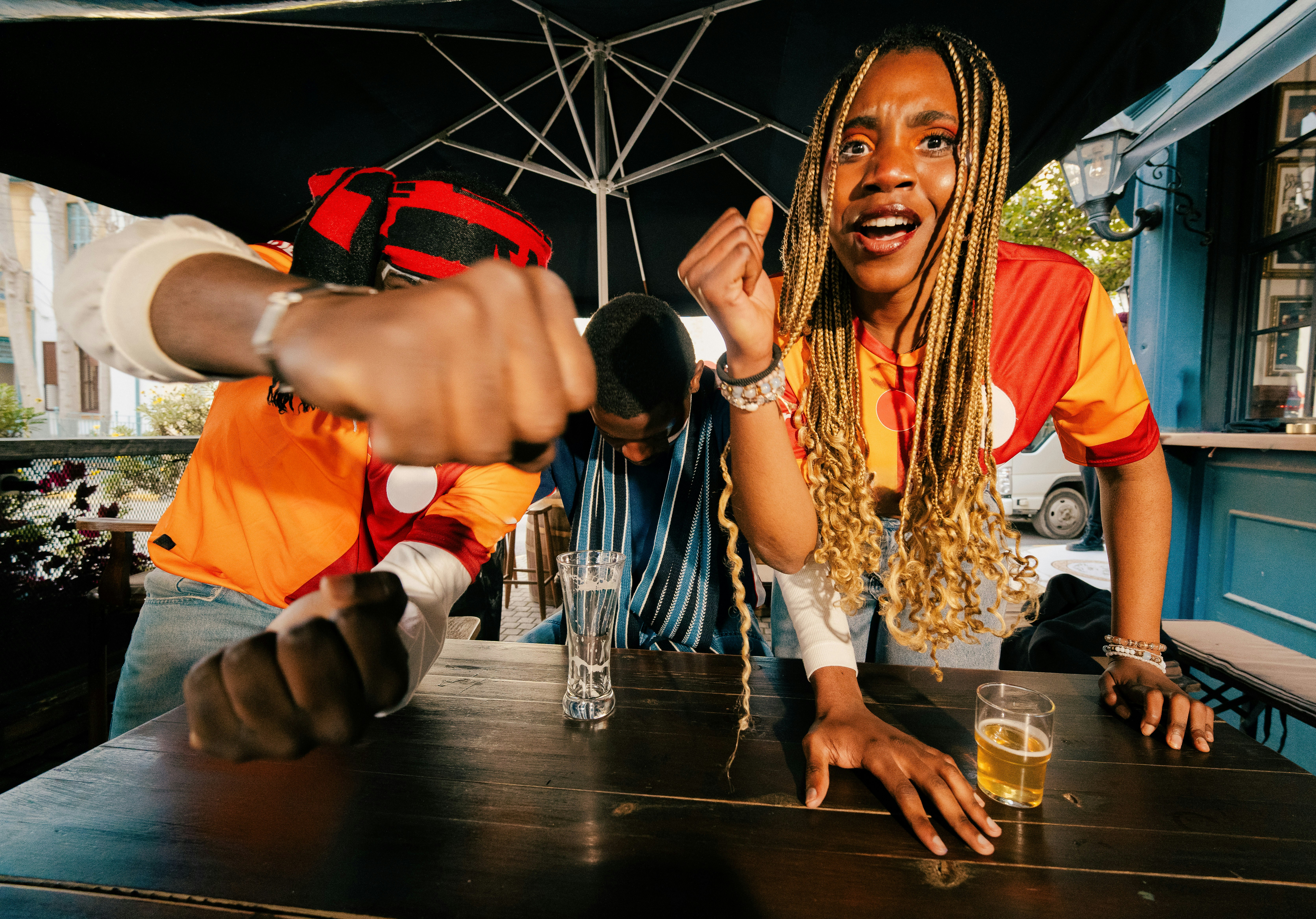 Bustling Café Chaos: Two jubilant friends rally at the outdoor table