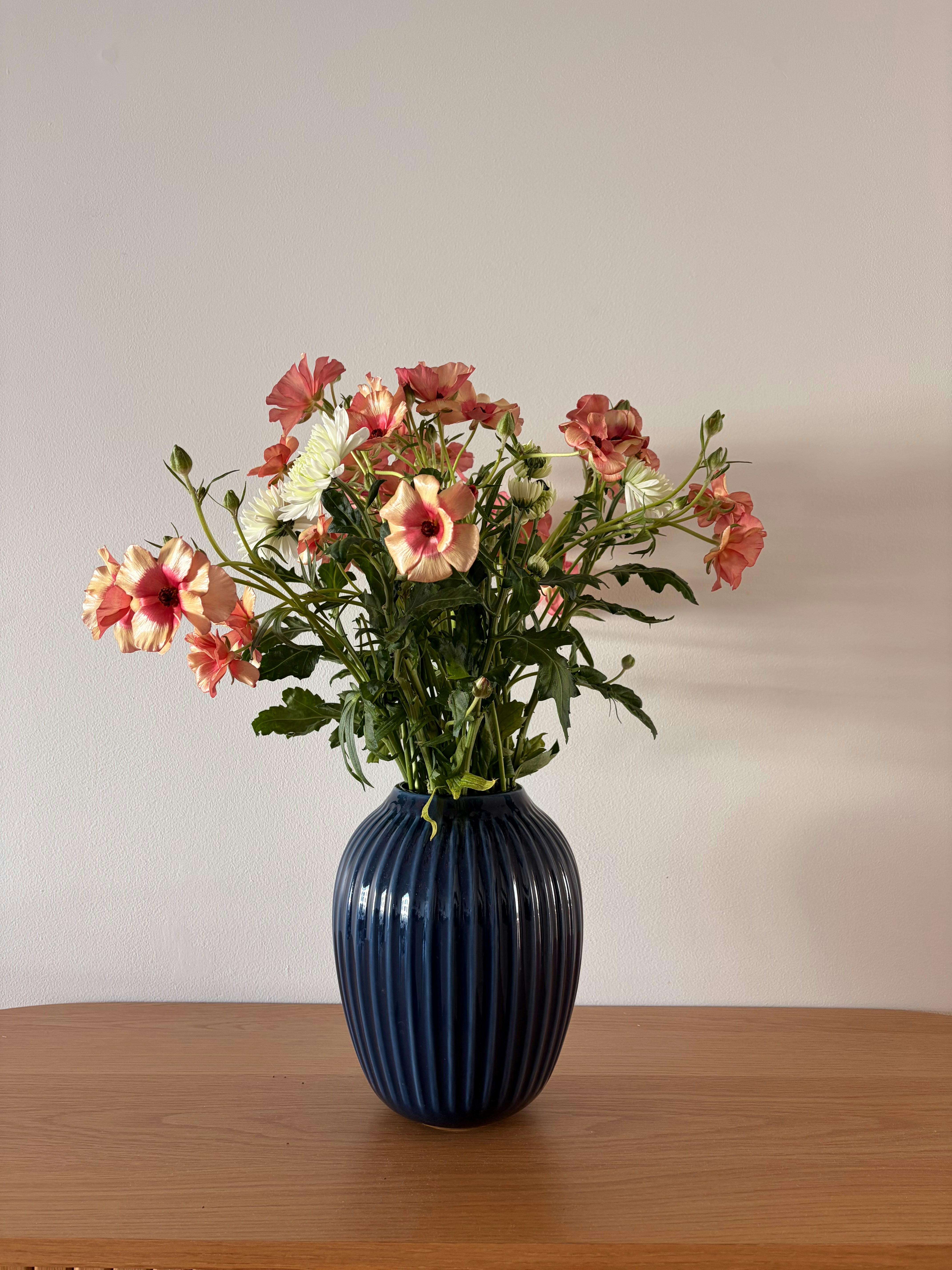 Vibrant Bouquet in a Striated Blue Vase Anchored on a Wooden Table