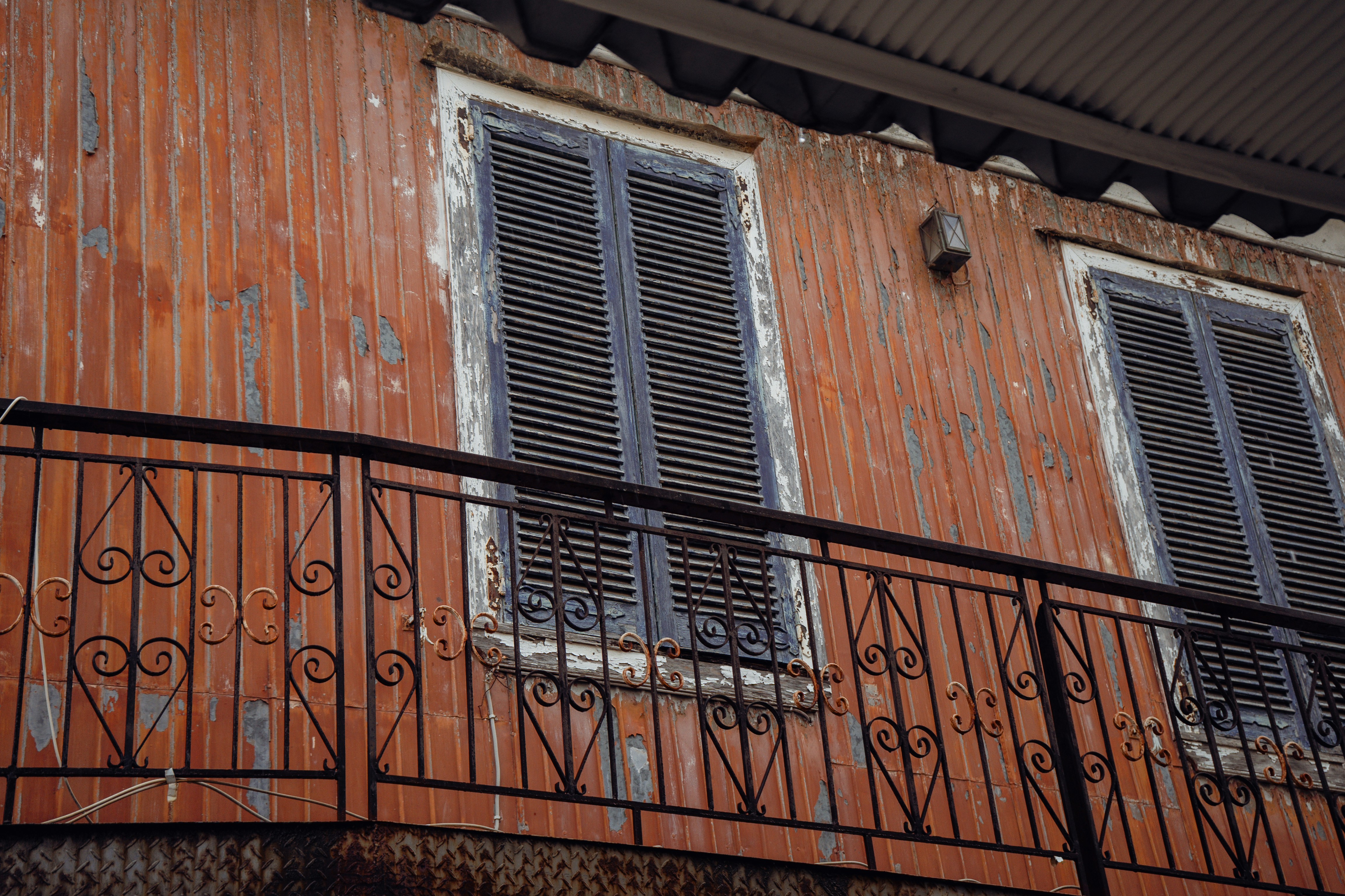 Weathered Balcony Doors: A Study in Rust and Repetition