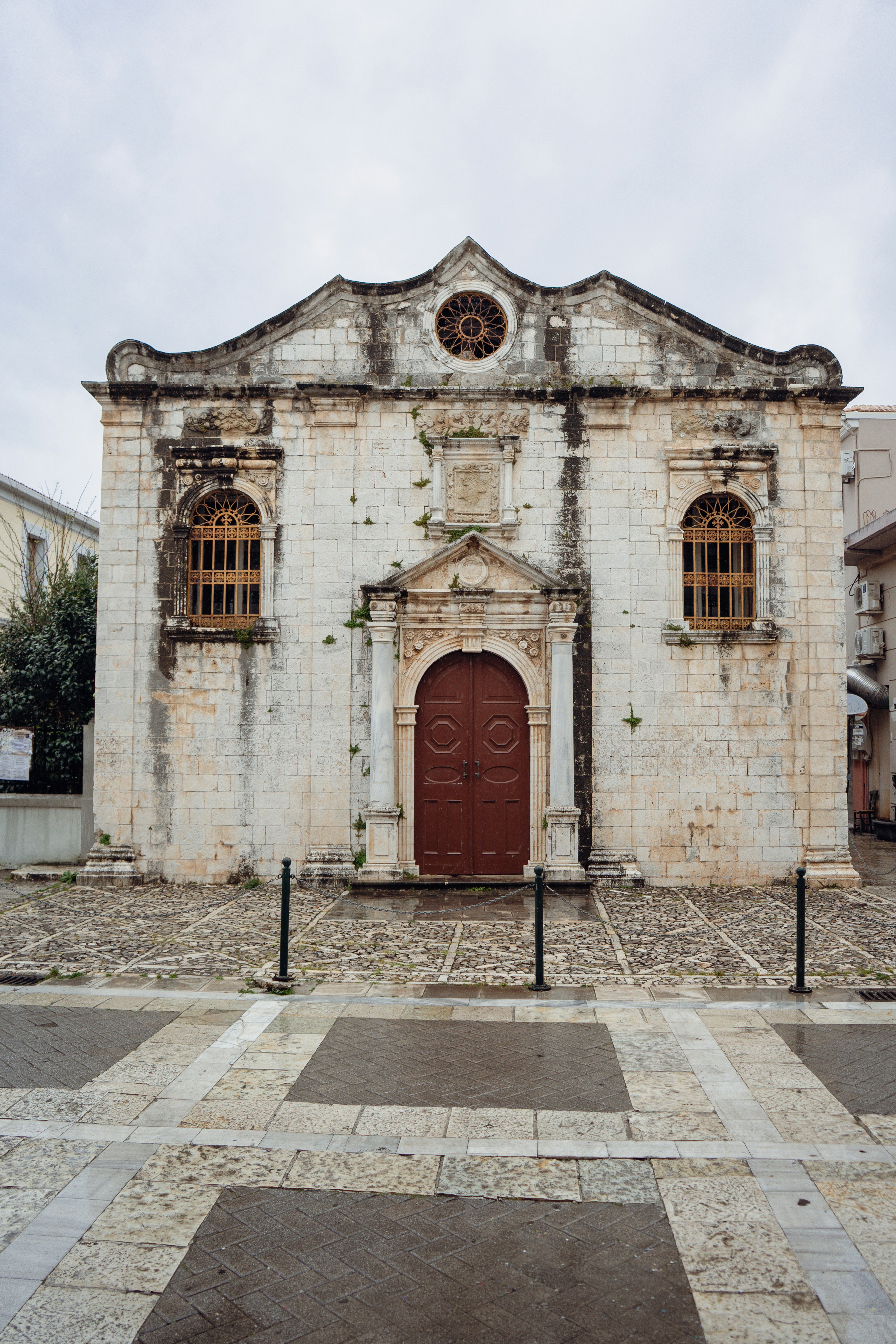 Deserted Chapel Facade: Weathered Stone and Rusted Doorway