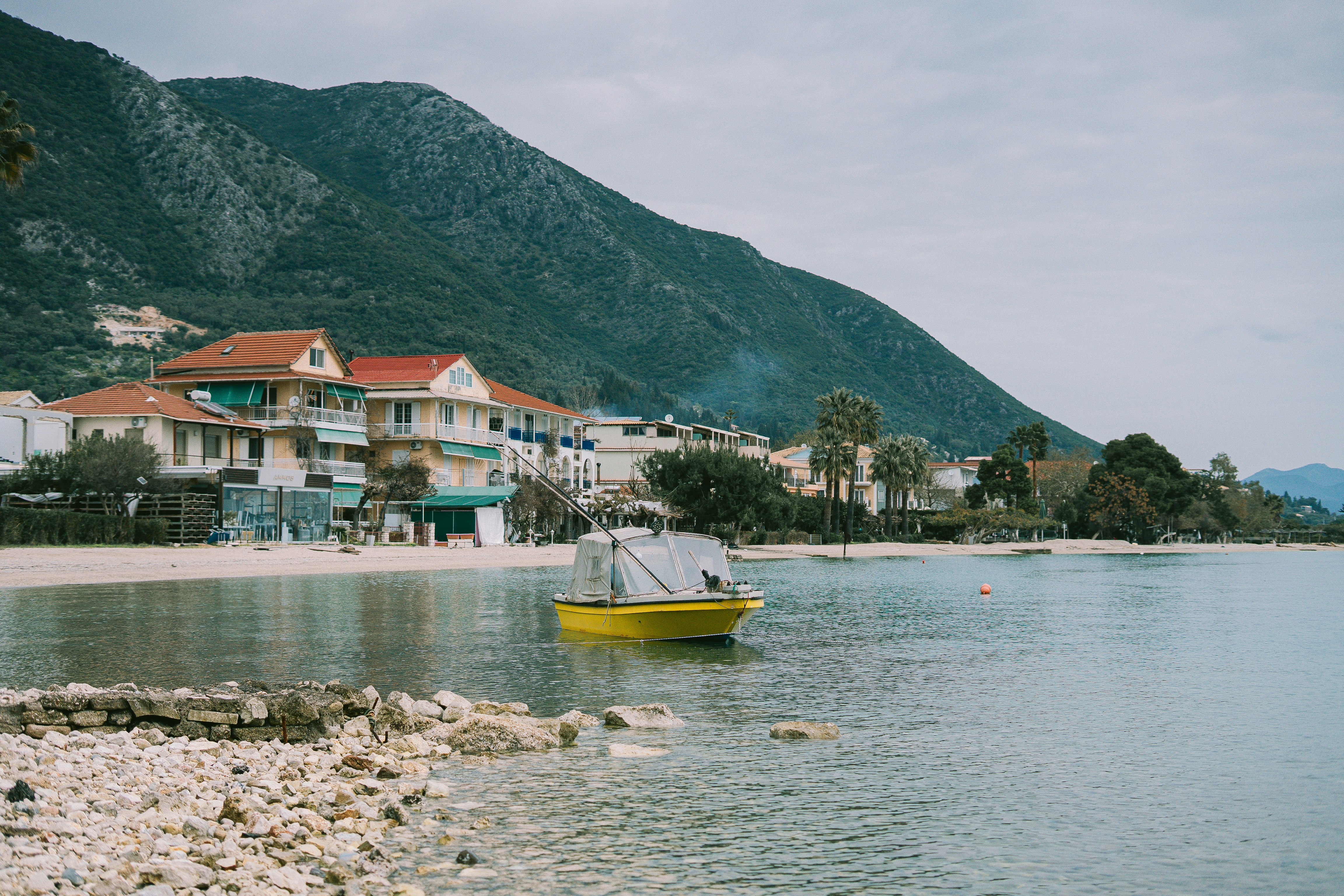 Yellow Boat in a Quiet Harbour Framed by Coastal Homes and Mountains, Greece-like