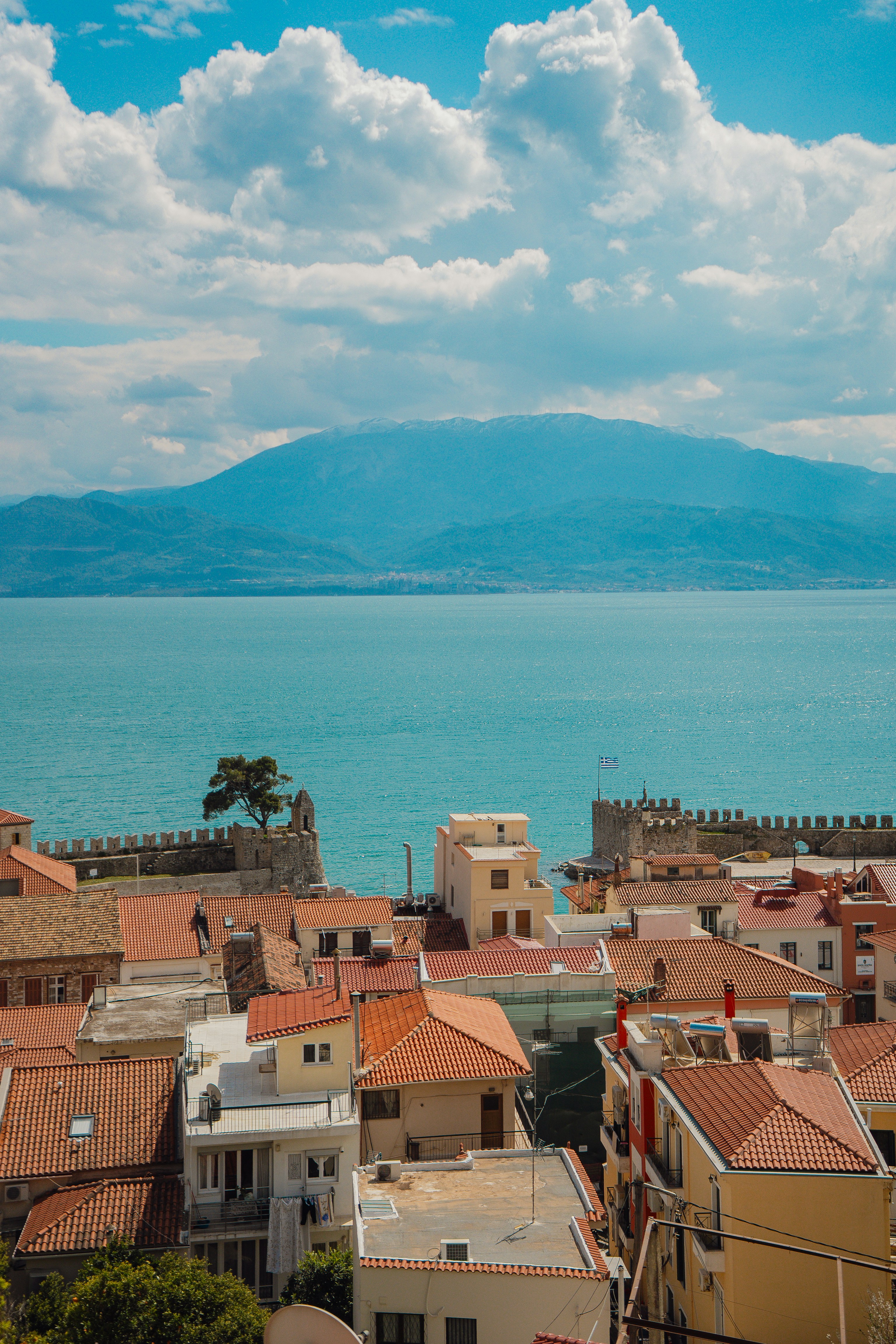 Coastal Village Cascade: Red Tiled Rooftops Beneath a Sea-blue Horizon