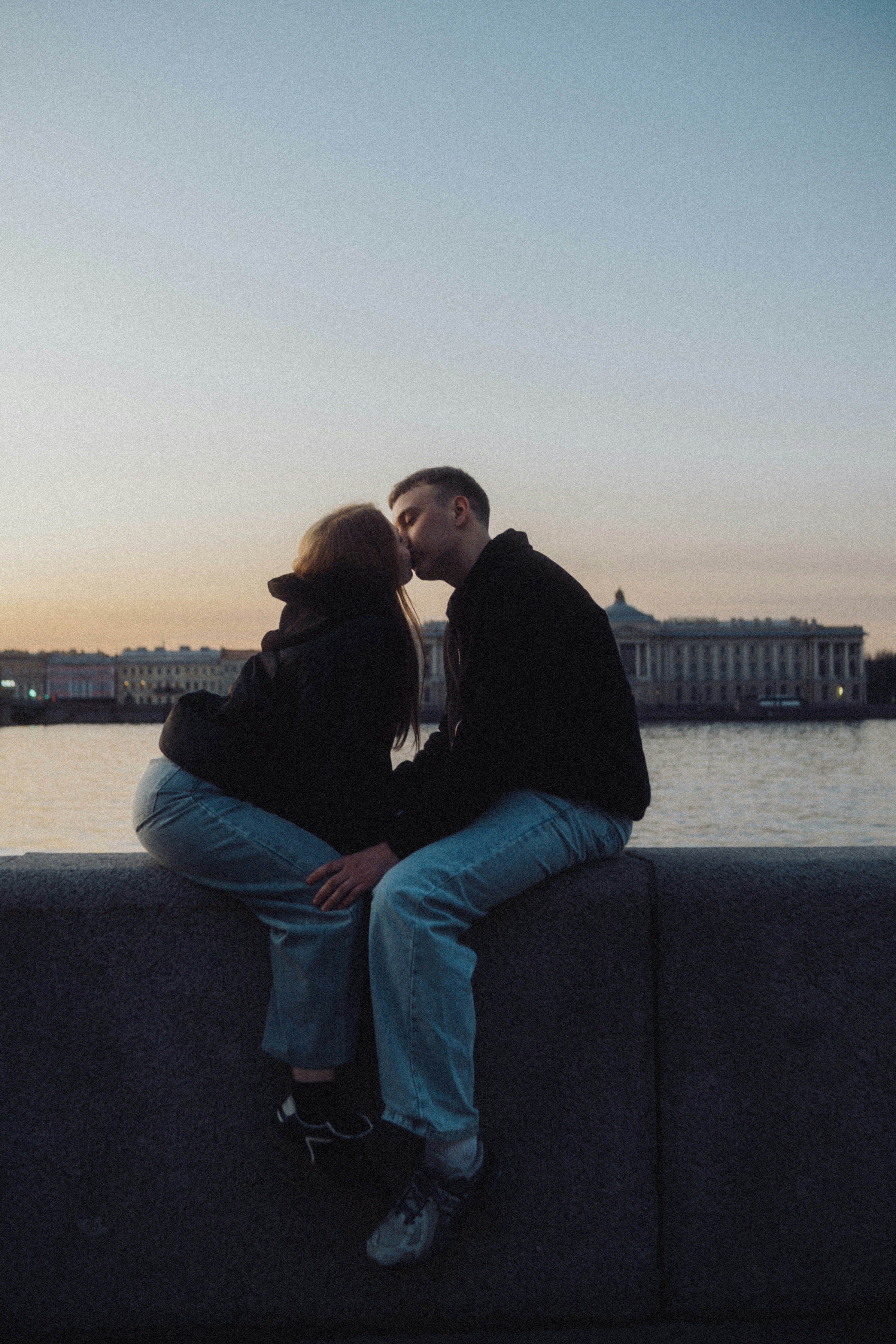 Kiss at the Riverfront: Quiet Evening Embrace