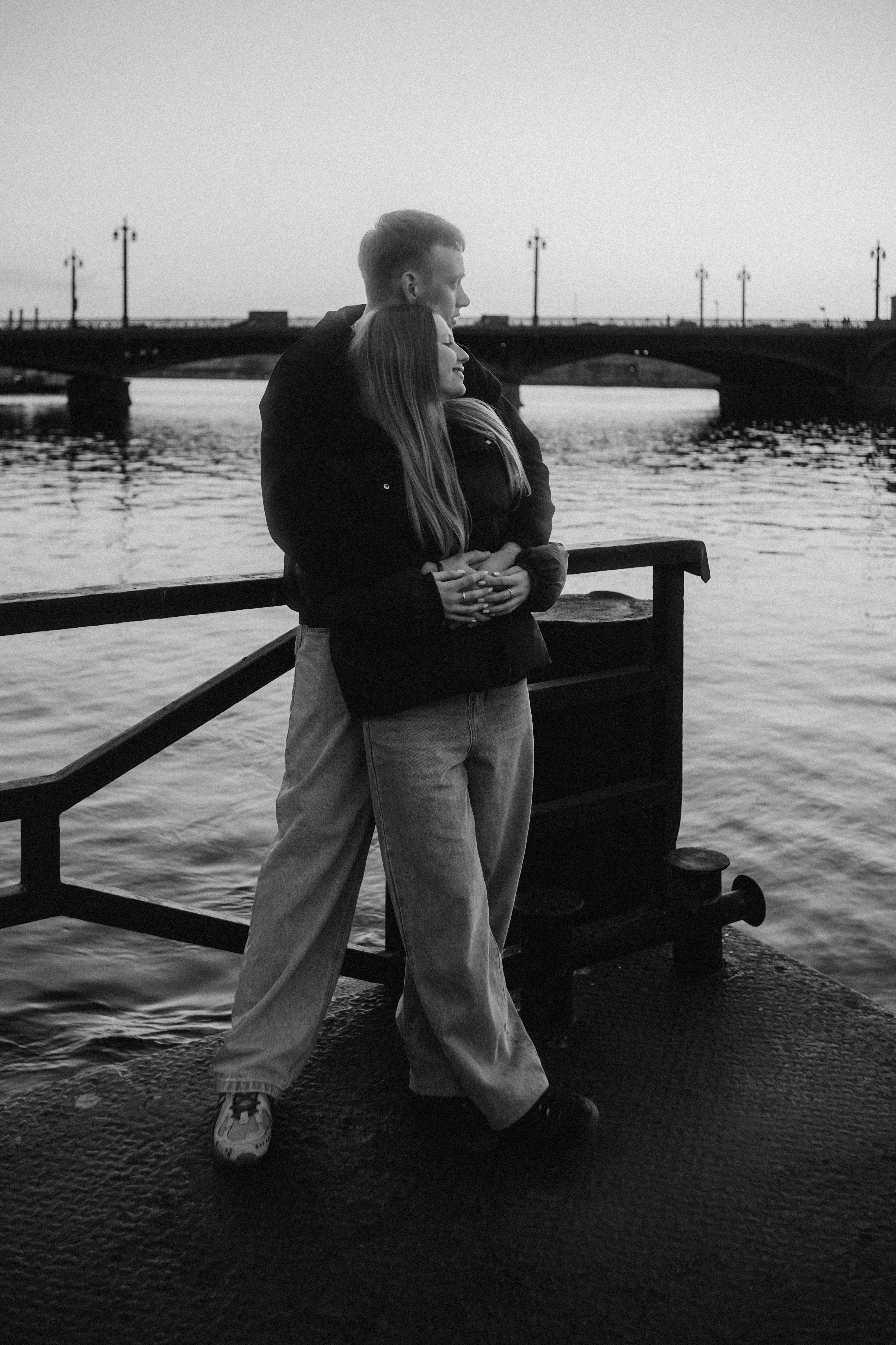 Embrace by the Riverside: A Quiet Moment on the Pier