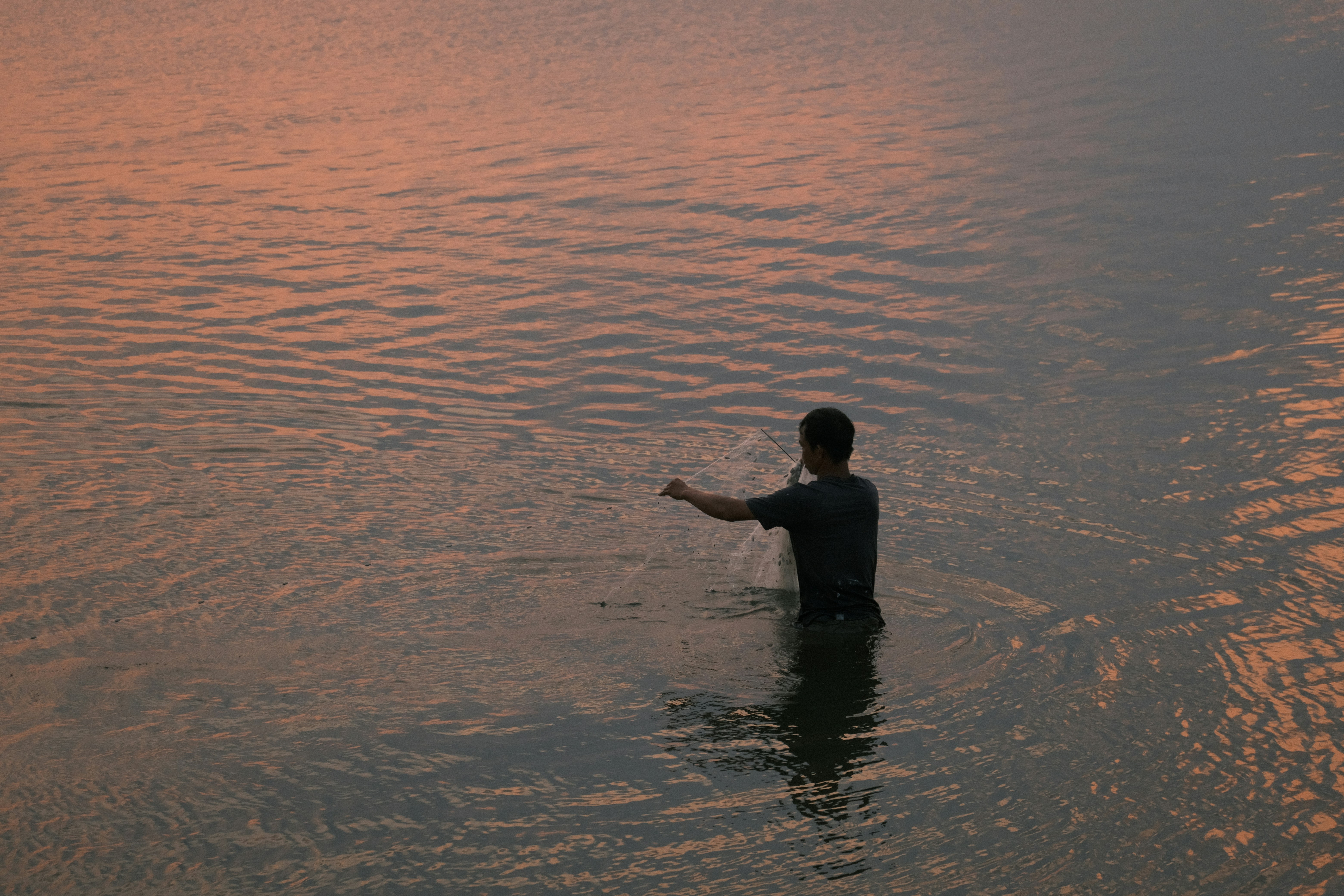 Descent into Quiet: A lone figure in amber-tinted water