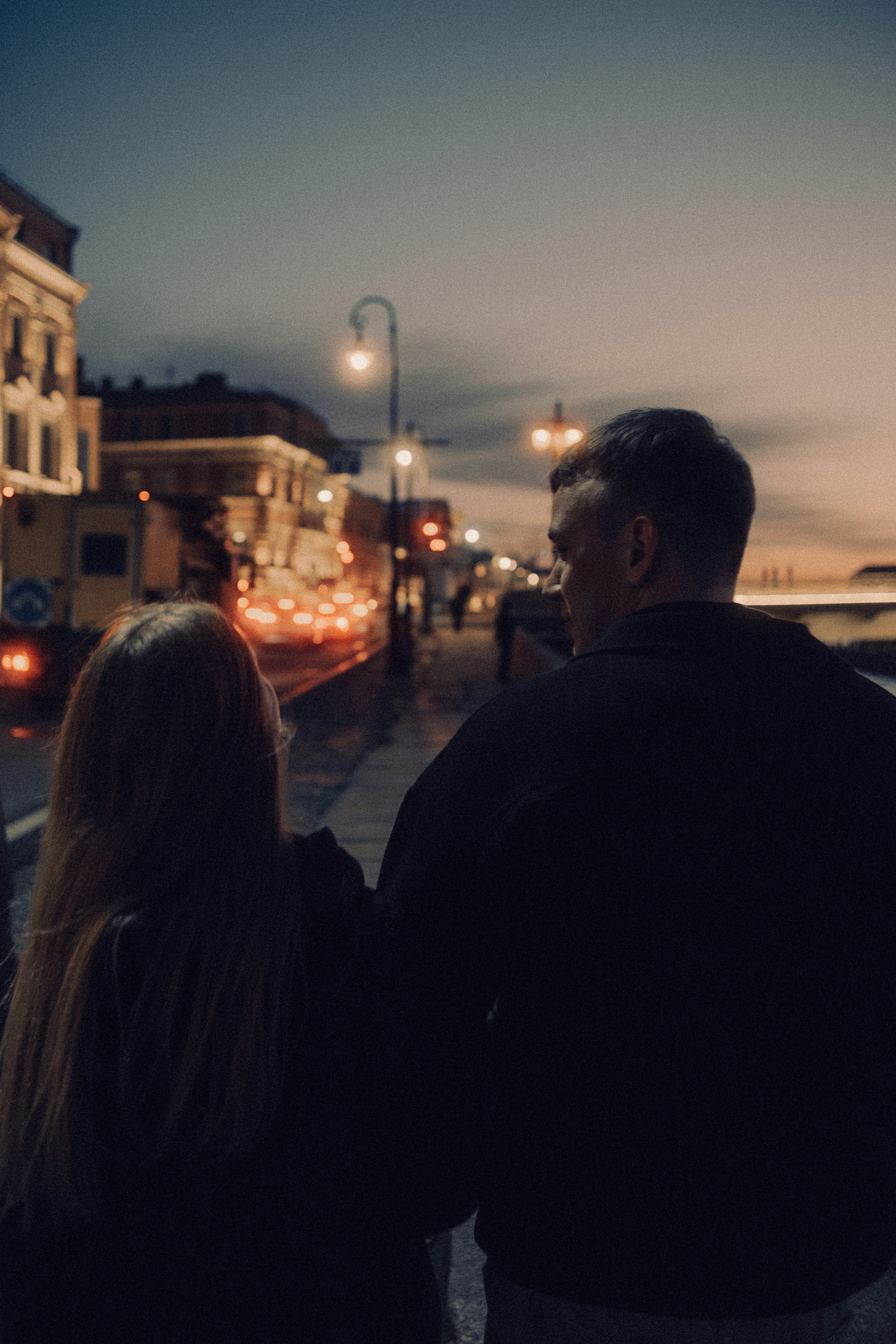 City Lights Embrace: A Quiet Moment Behind the Crowd