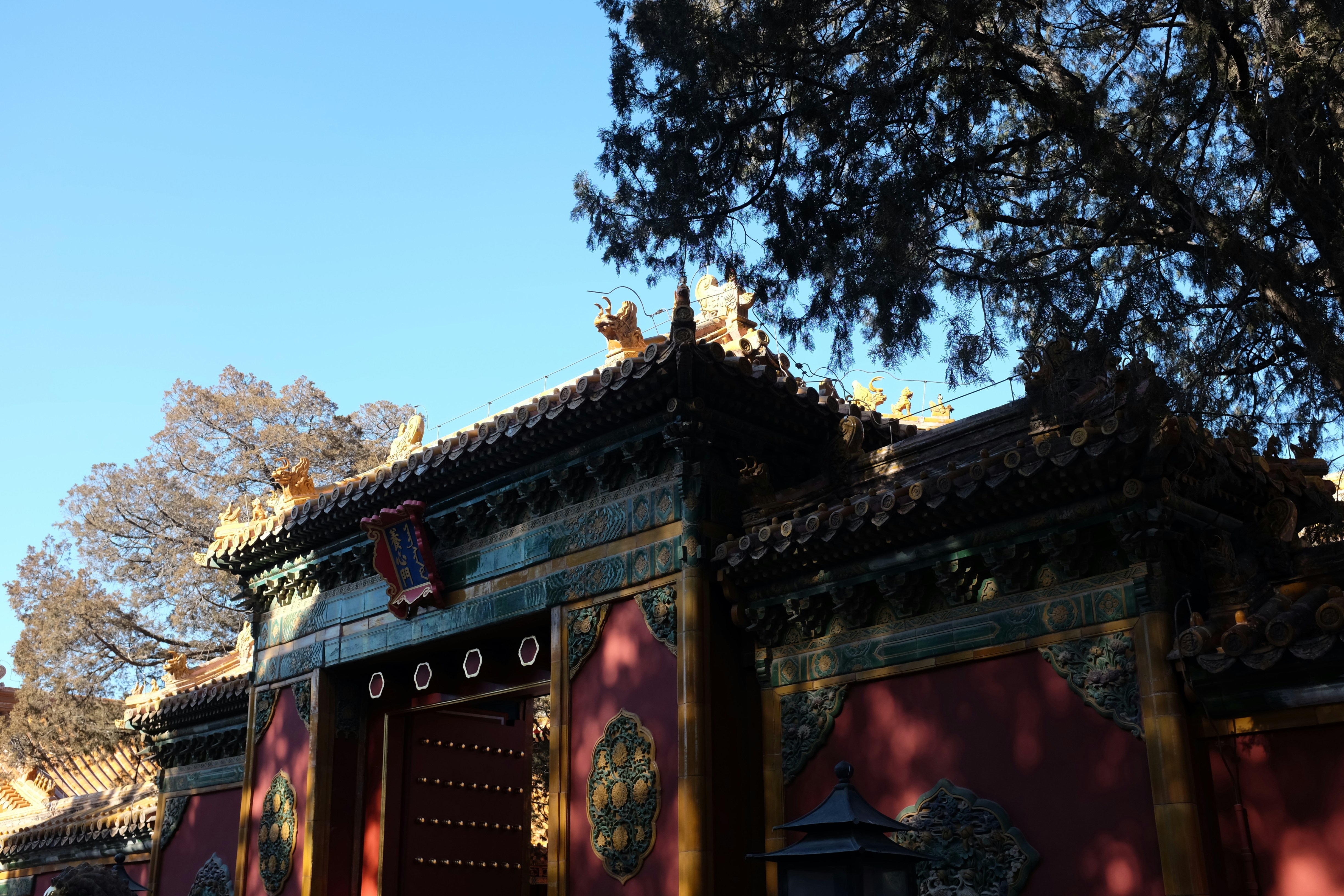 Sunlit Guardians: A Chinese Temple Facade Under Crescent Shade