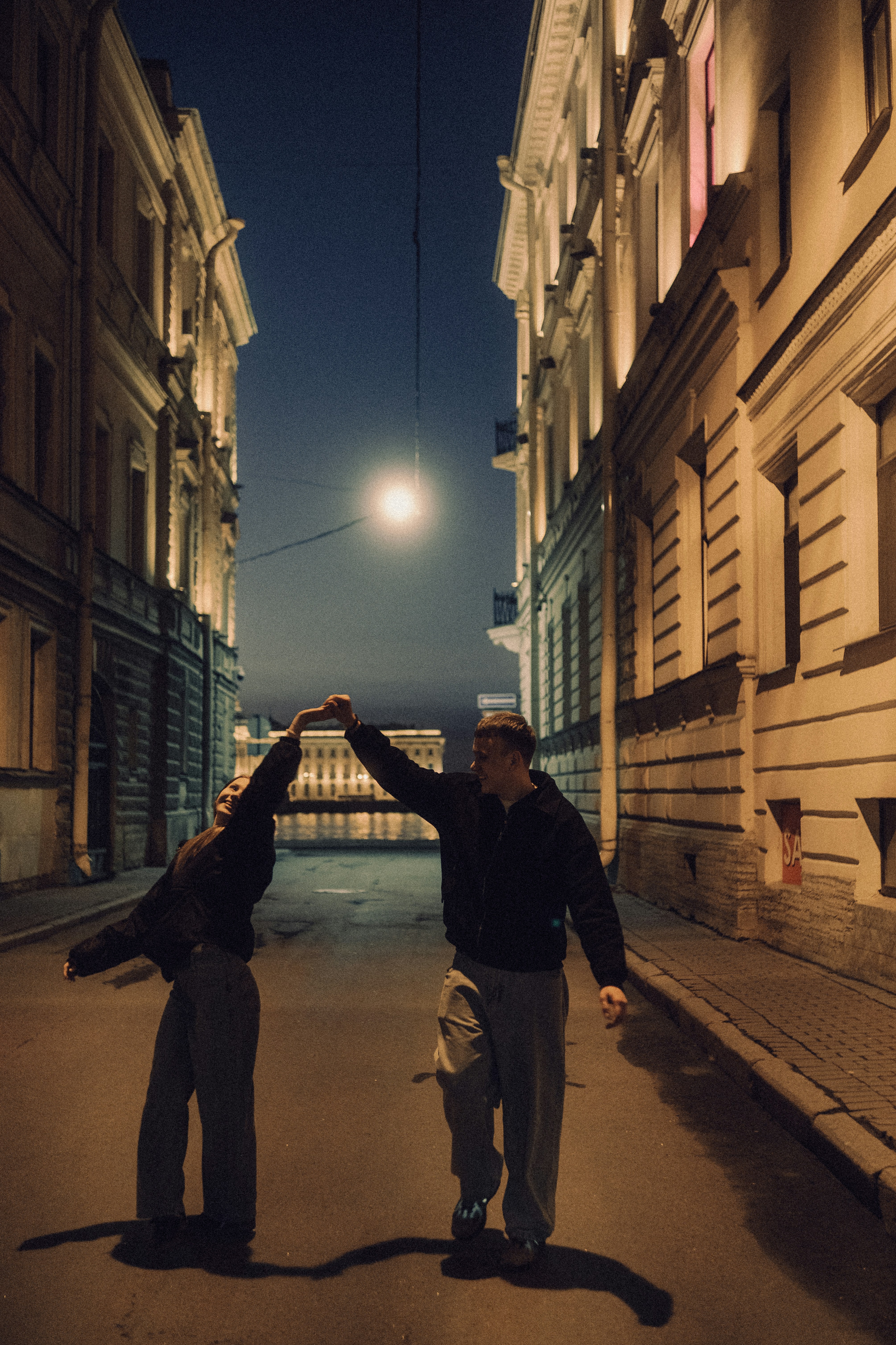 High-Five Under a Streetlamp: Nightlife Embrace on a Quiet Street