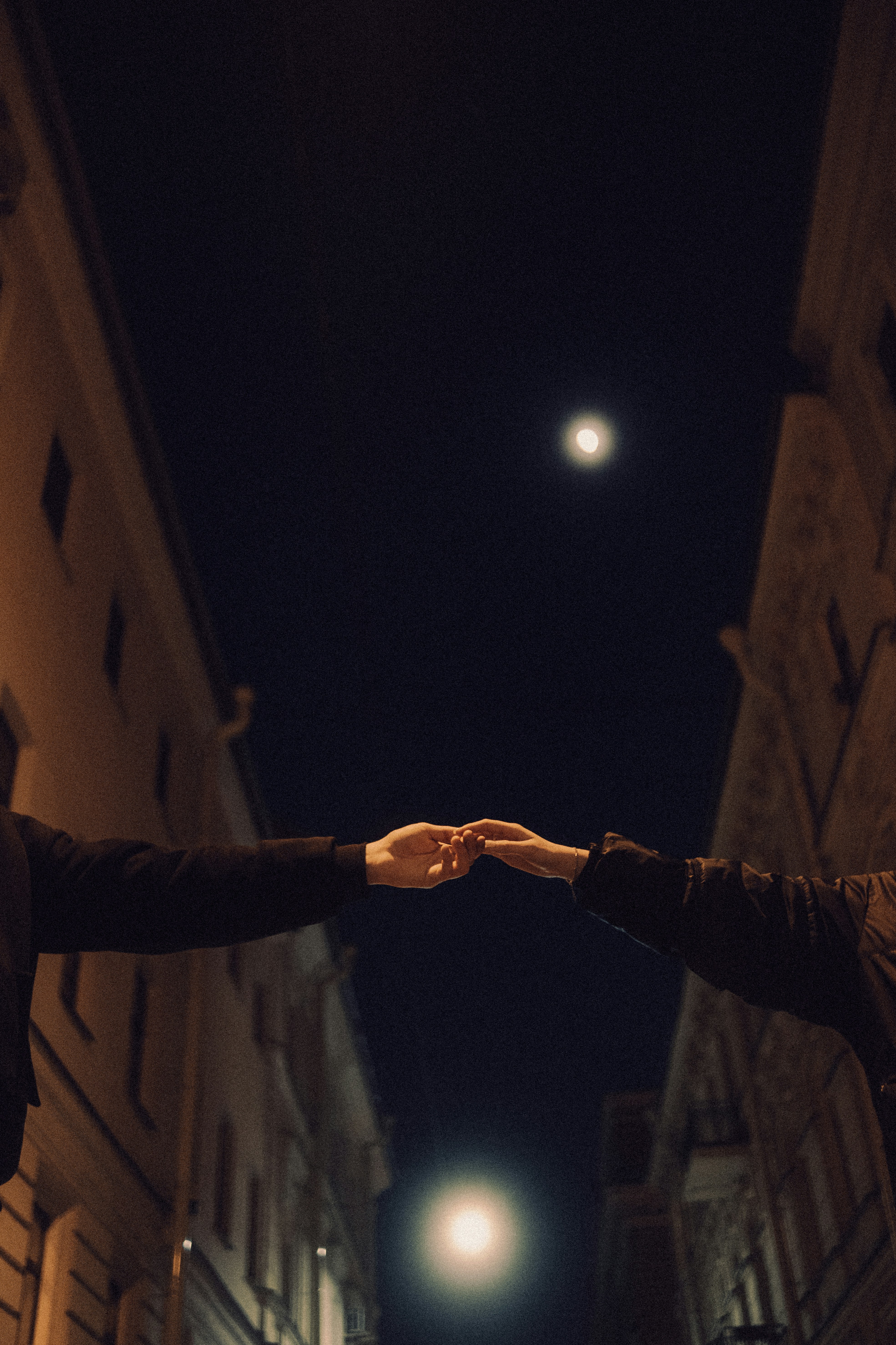 Hands Crossing Under a Moonlit Night in the Street