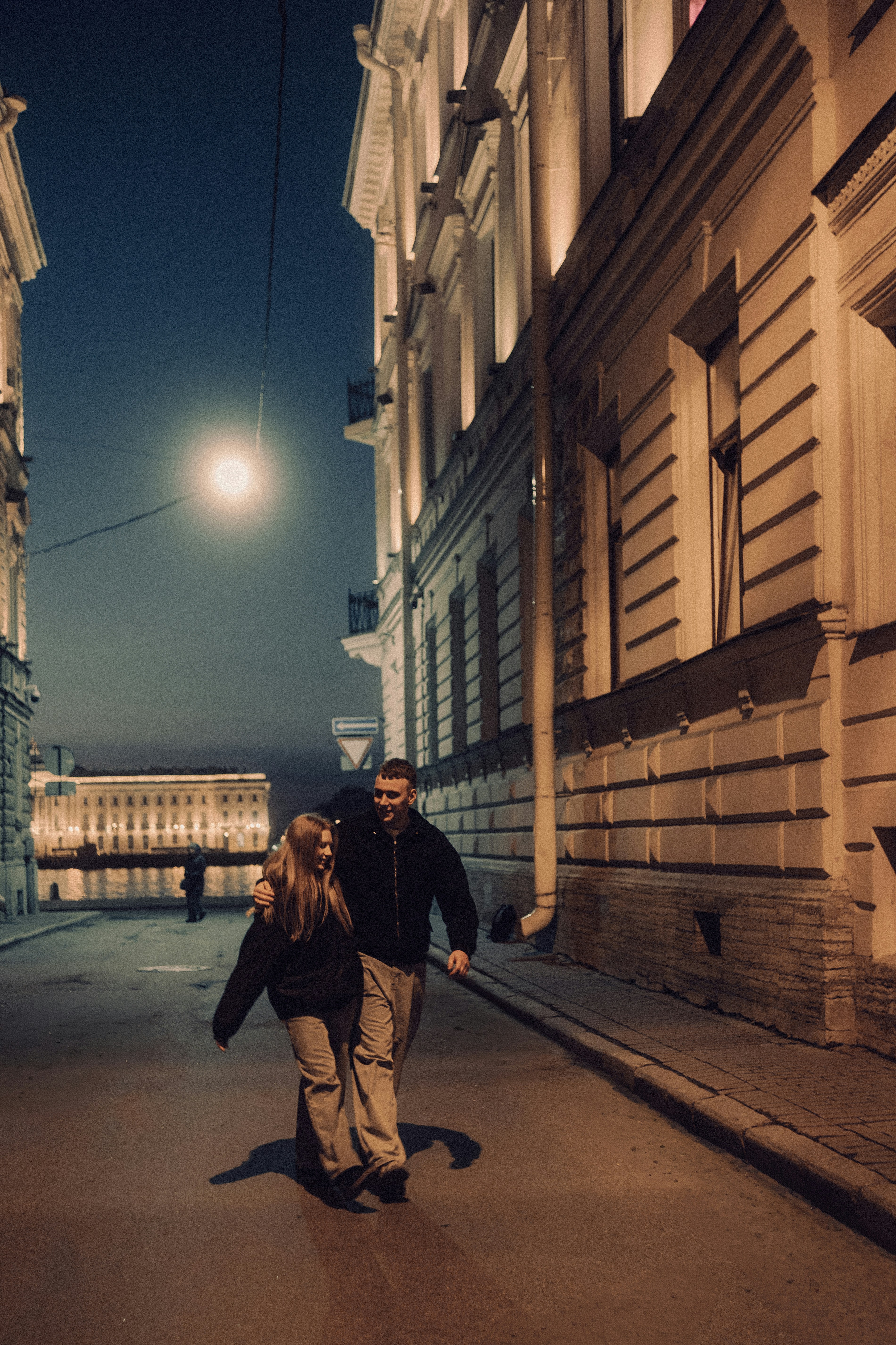 Night Stroll: A Couple Shares a Quiet Moment Under Warm Streetlight