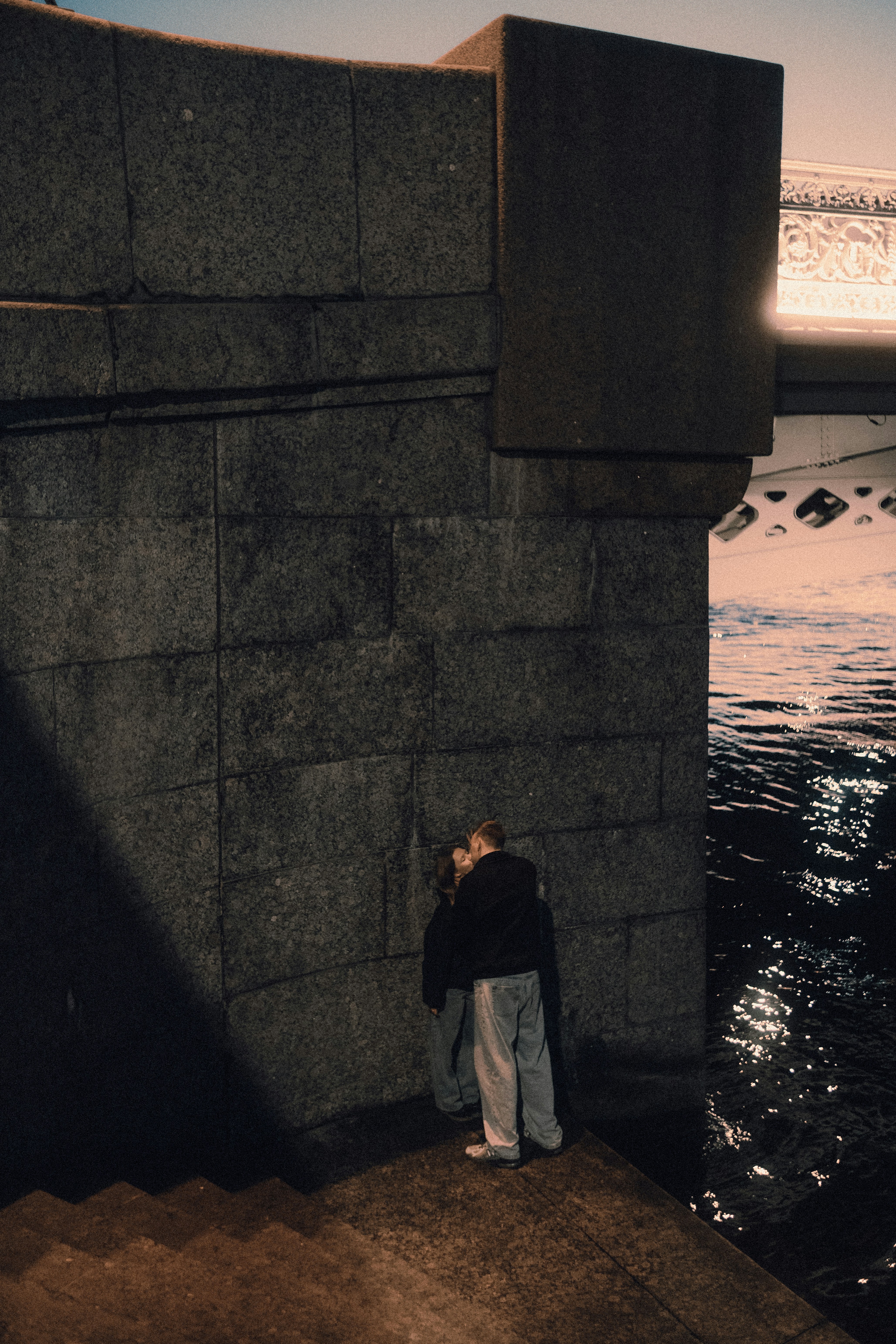 Liminal Moment by the Water: Two Figures at the Edge of a Waterfront Structure