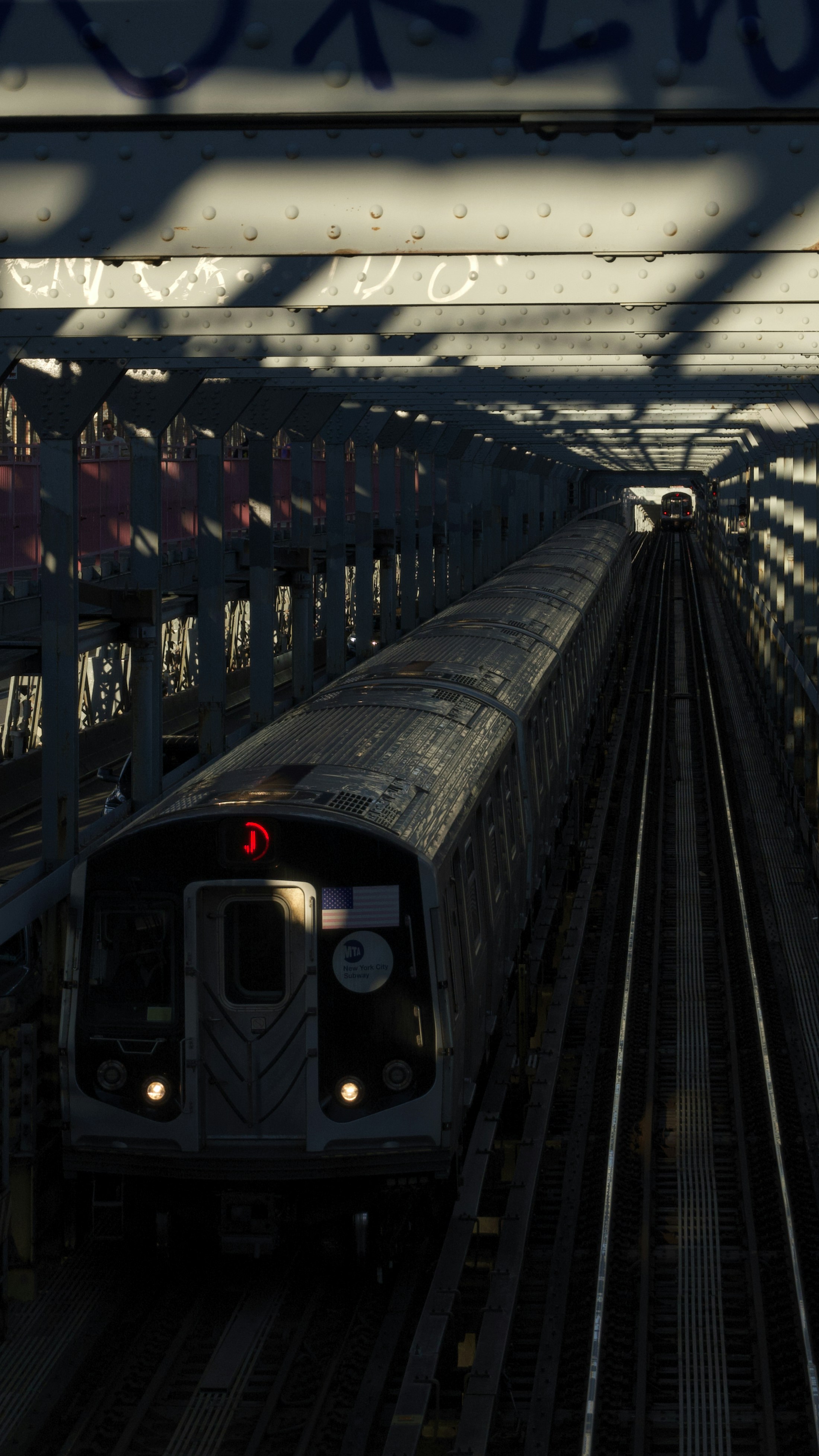 Ridge of Rails: A Subway Train Emerges Through Narrow Steel Daylight