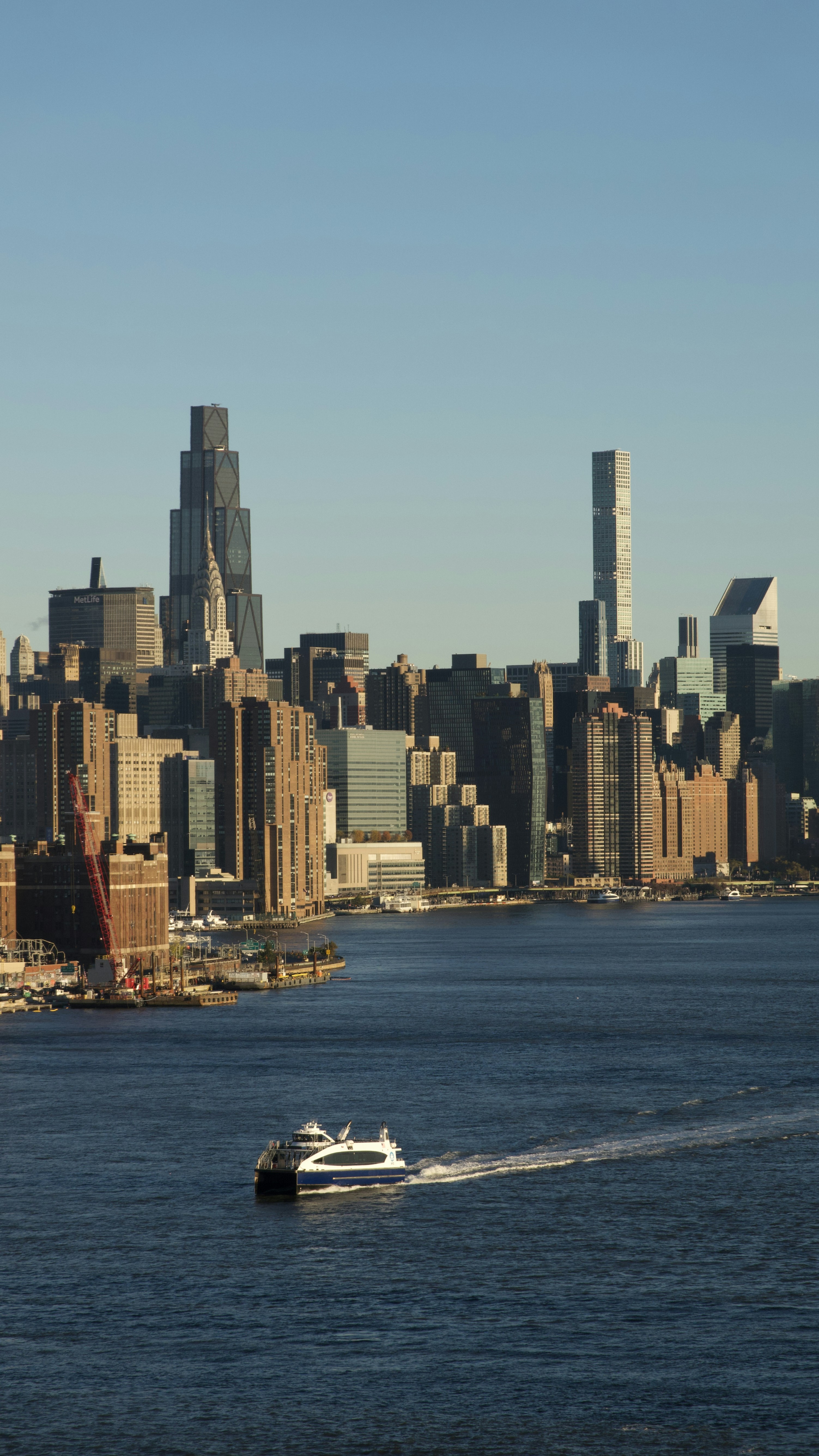 City by the River: Ferry Gliding Past the Skyline