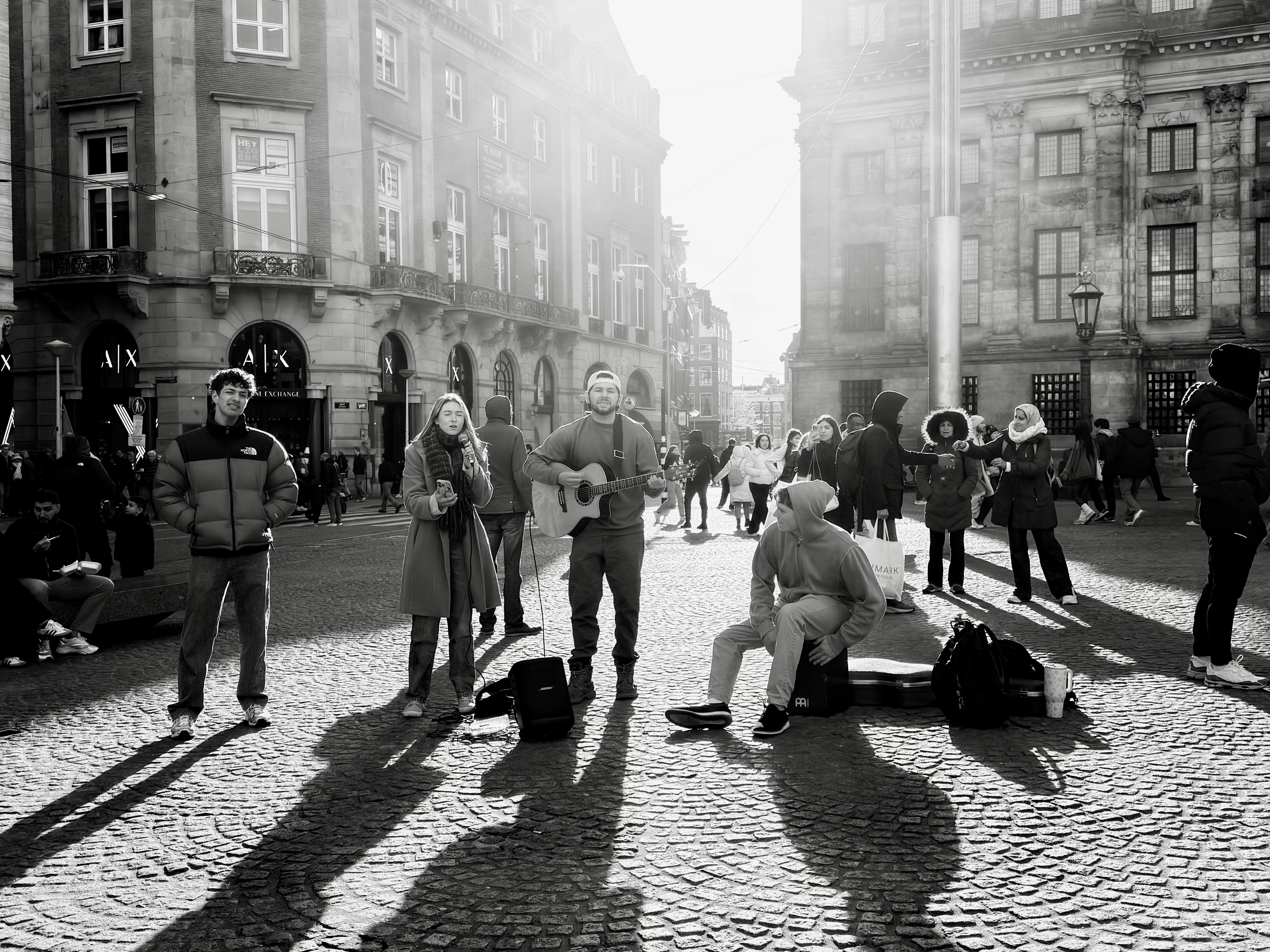 Street Buskers in Gentle Sunlight Cast Long Shadows on Cobblestones