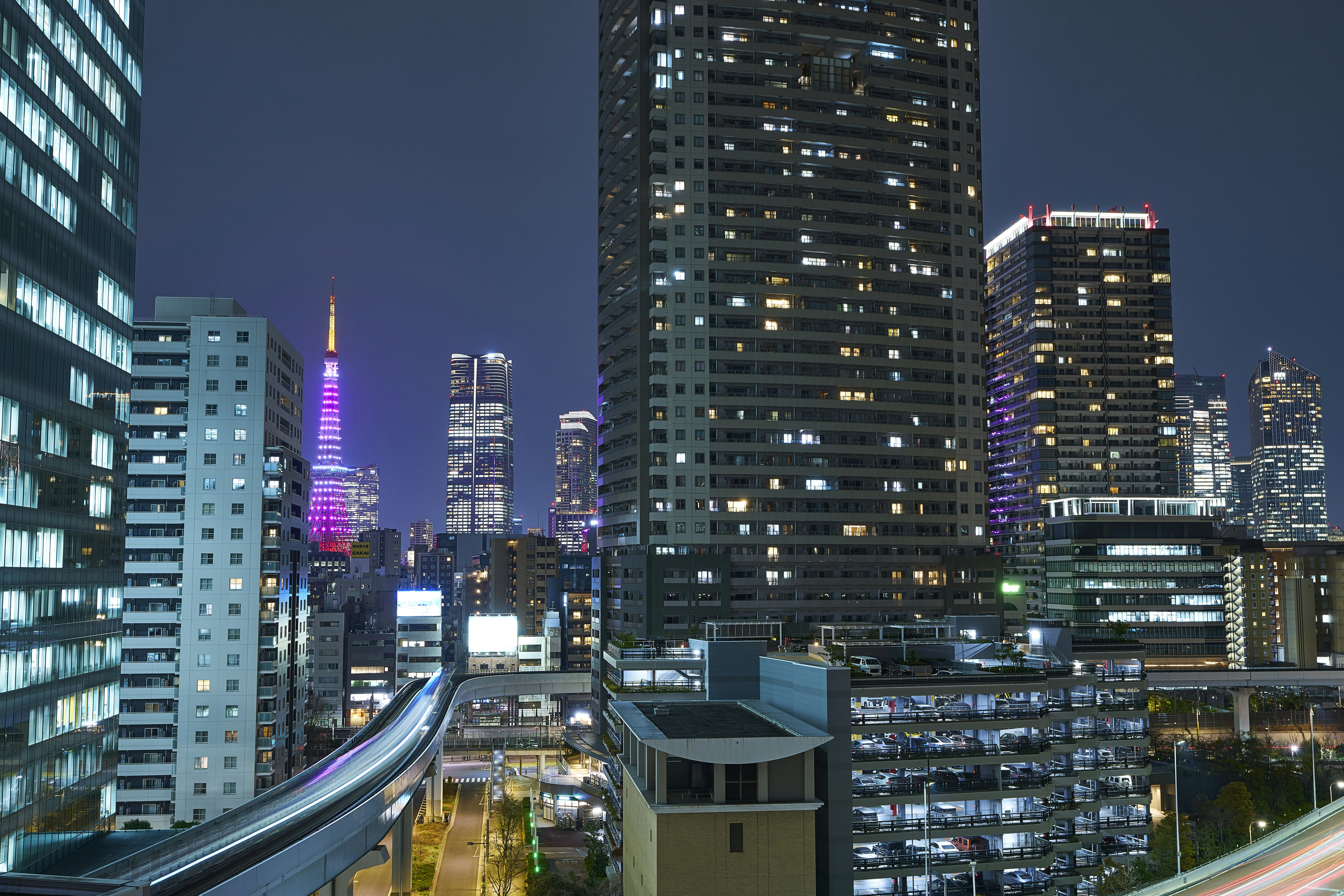 Neon Skyline Over a Railing: Nighttime Urban Panorama