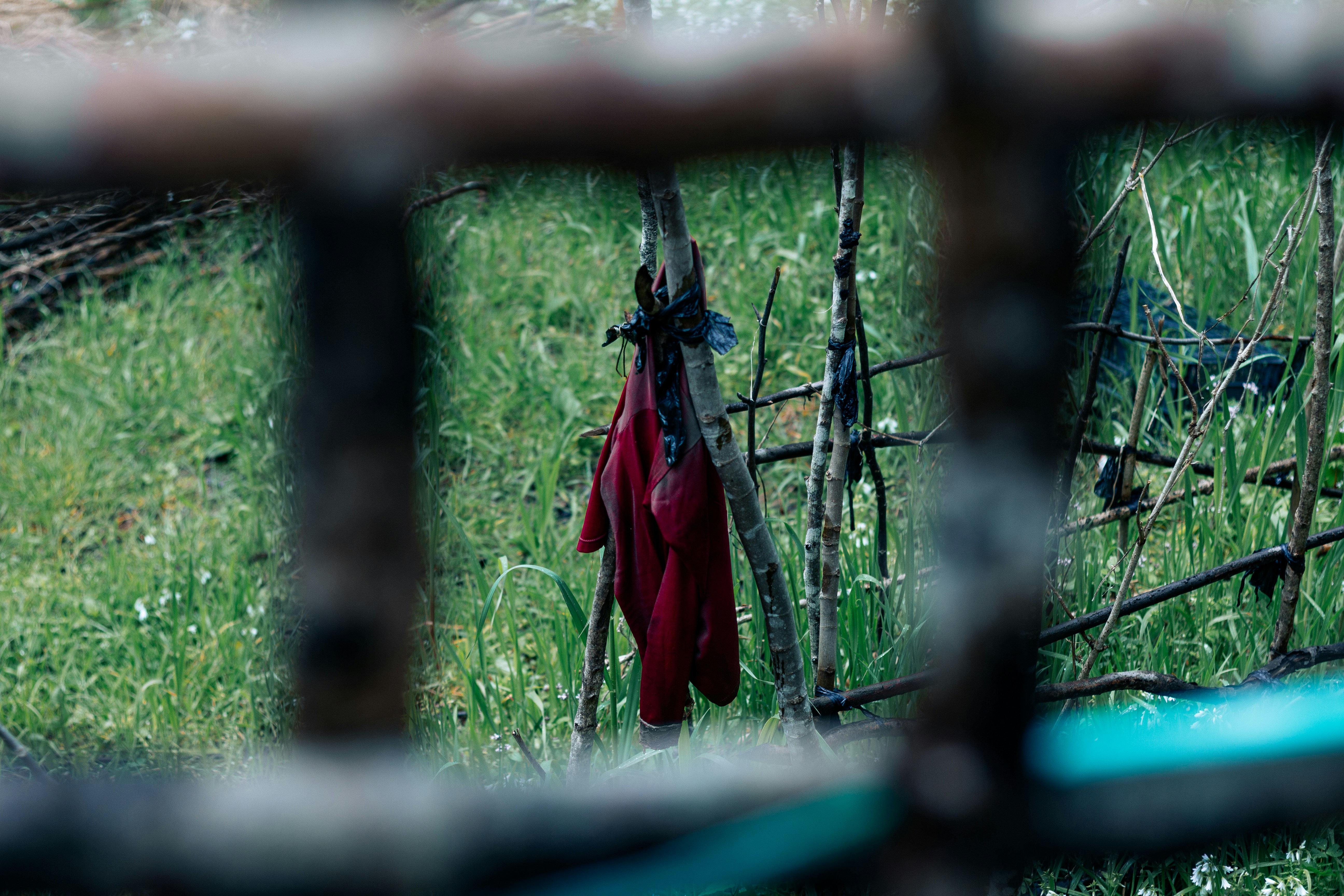 Red cloth in a rustic fence amid tall grass