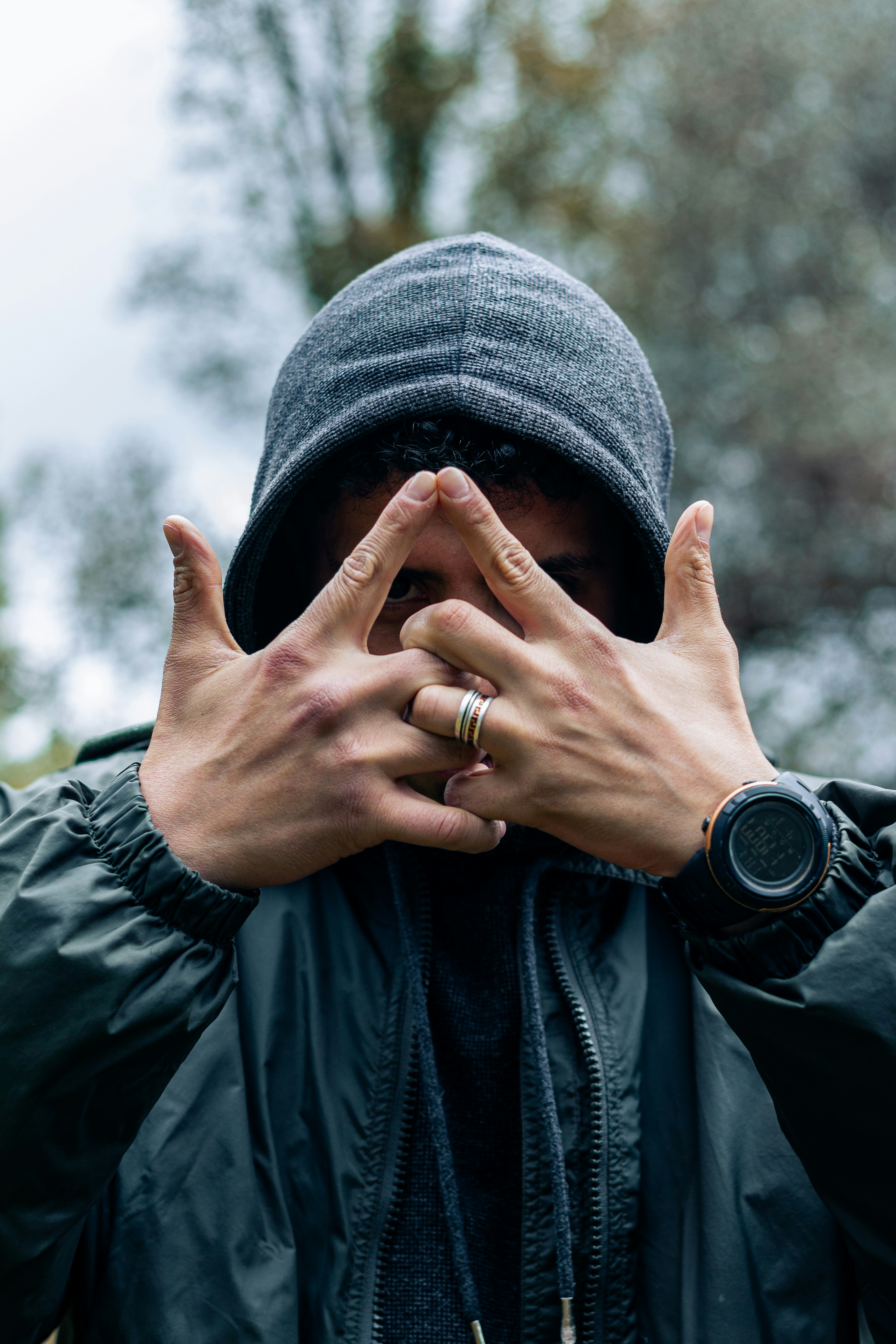 Hidden Gaze: Hands Framing the Face in a Hoodie
