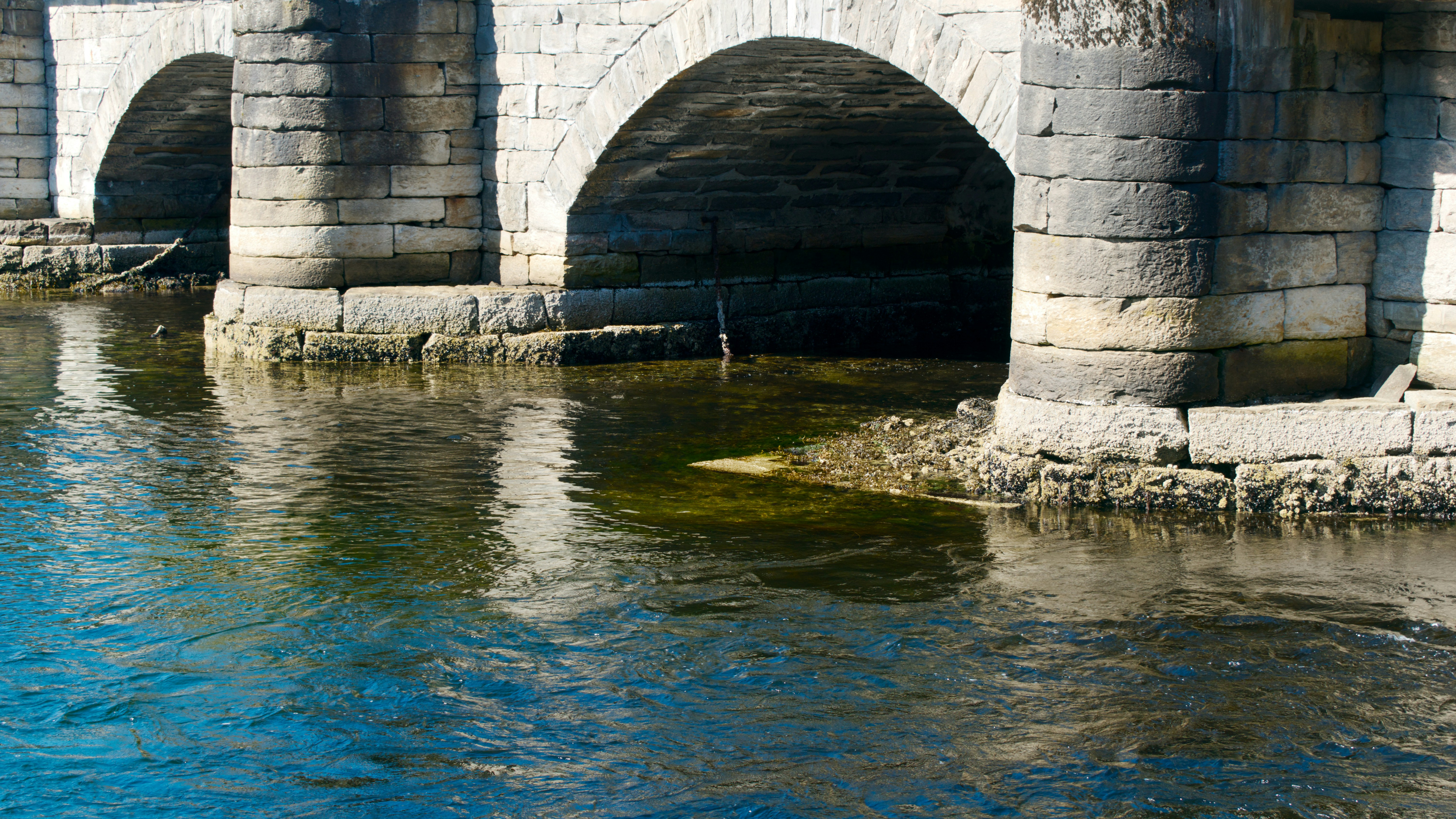 Stone Arcways and Tidal Light Under a Quiet Bridge