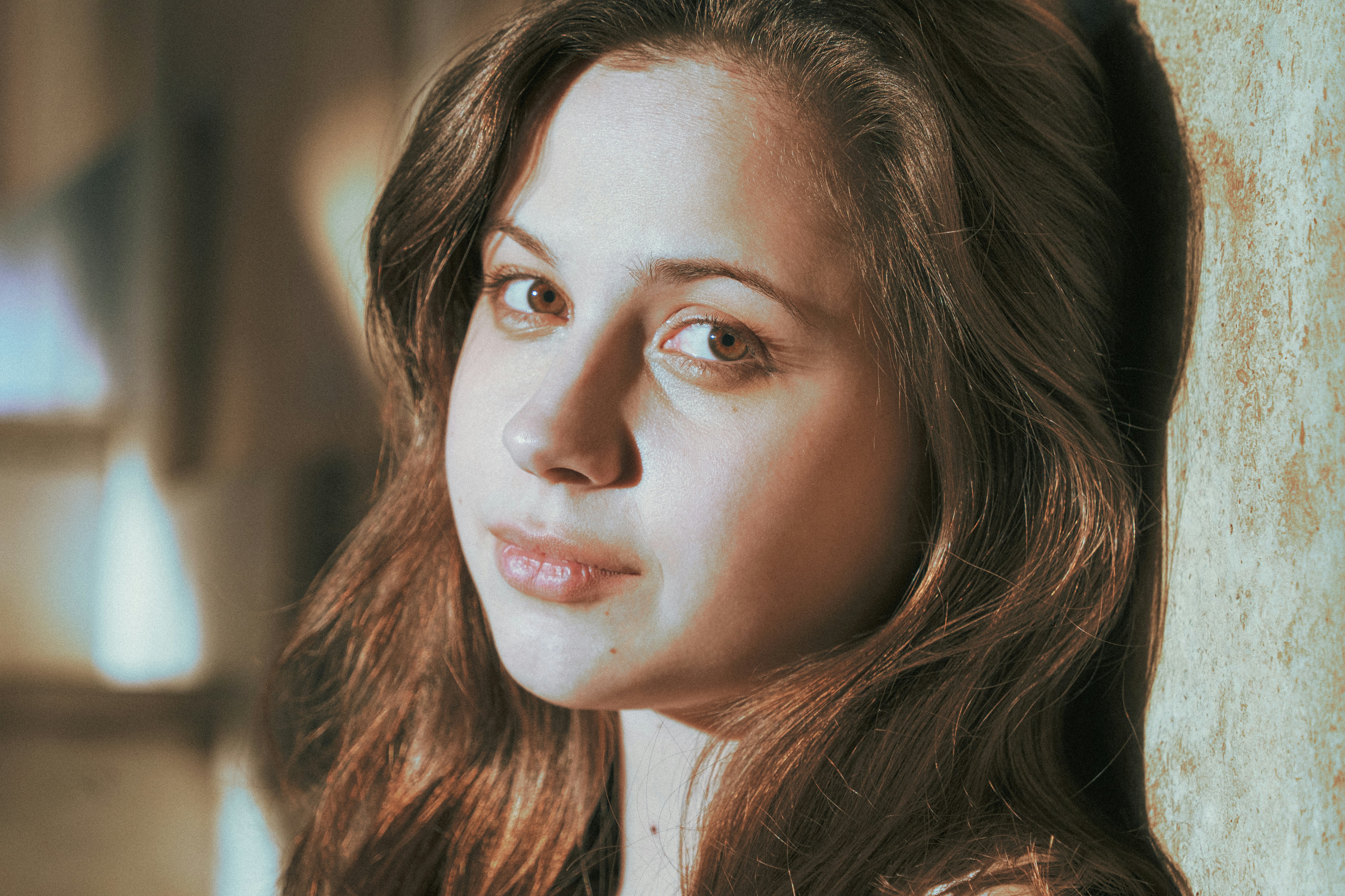 Soft Evening Portrait: Quiet Gaze by a Sunlit Wall