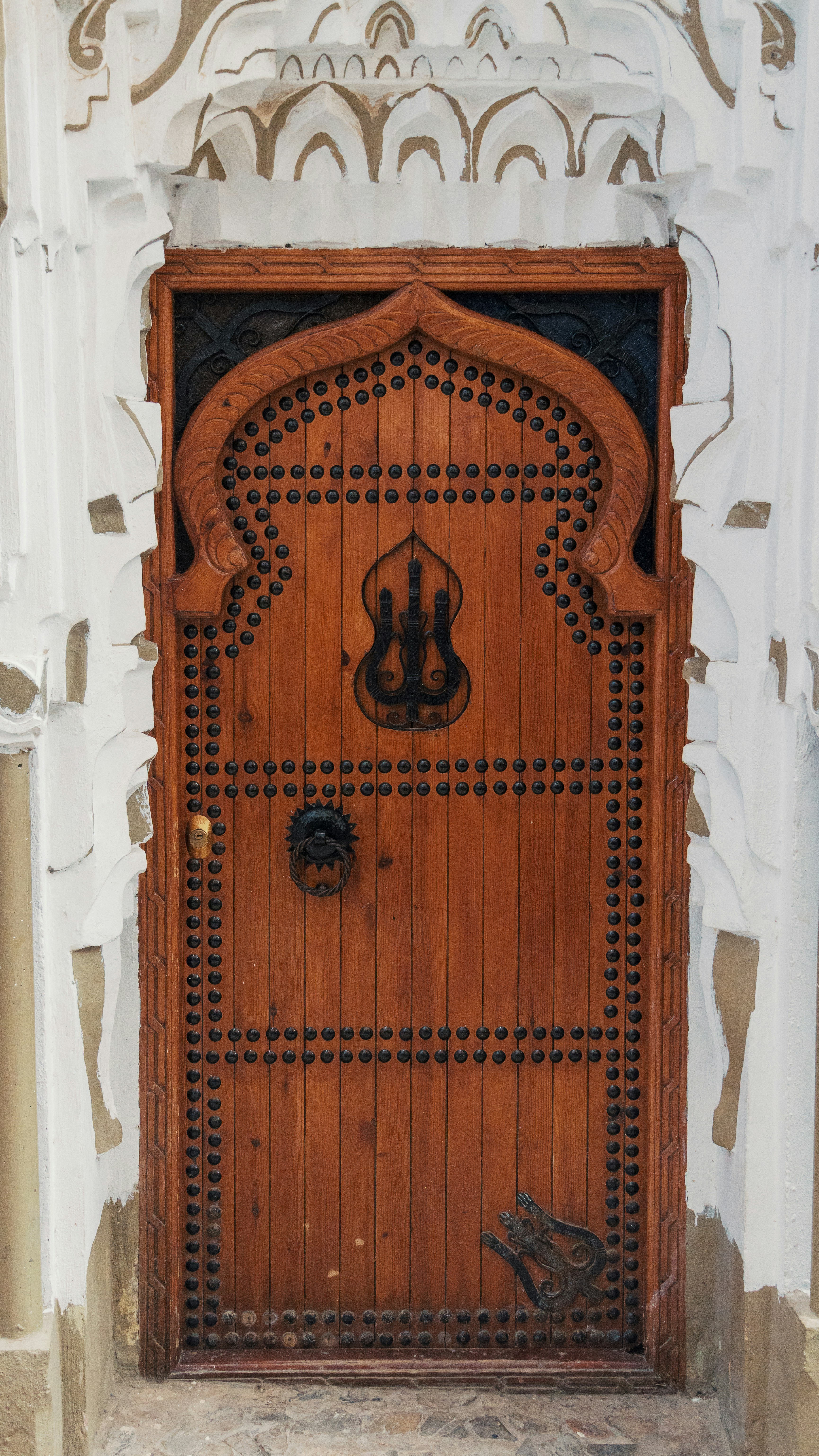 Ornate Wooden Door with Studded Archway