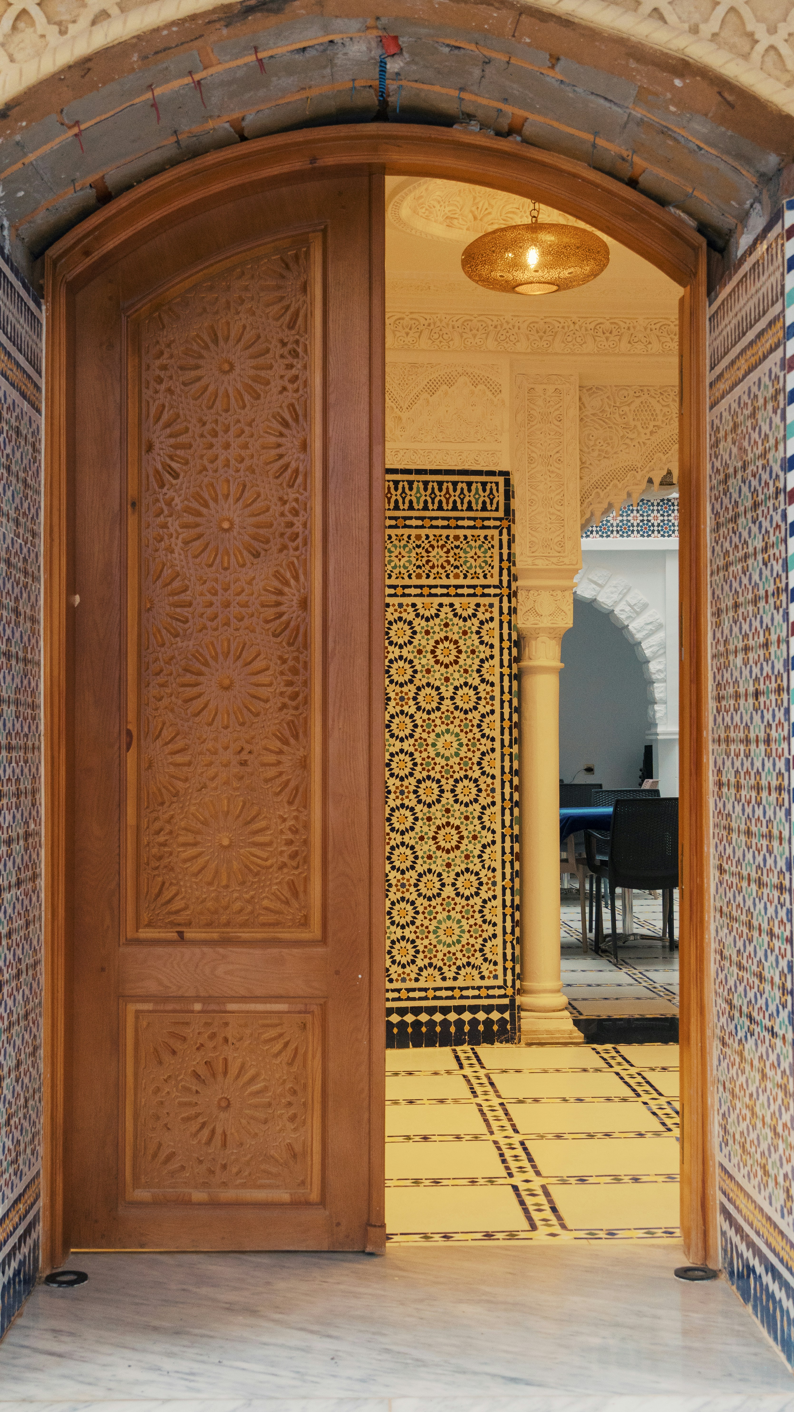 Doorway into a Tile-Decorated Hallway with Intricate Carved Wood Panels
