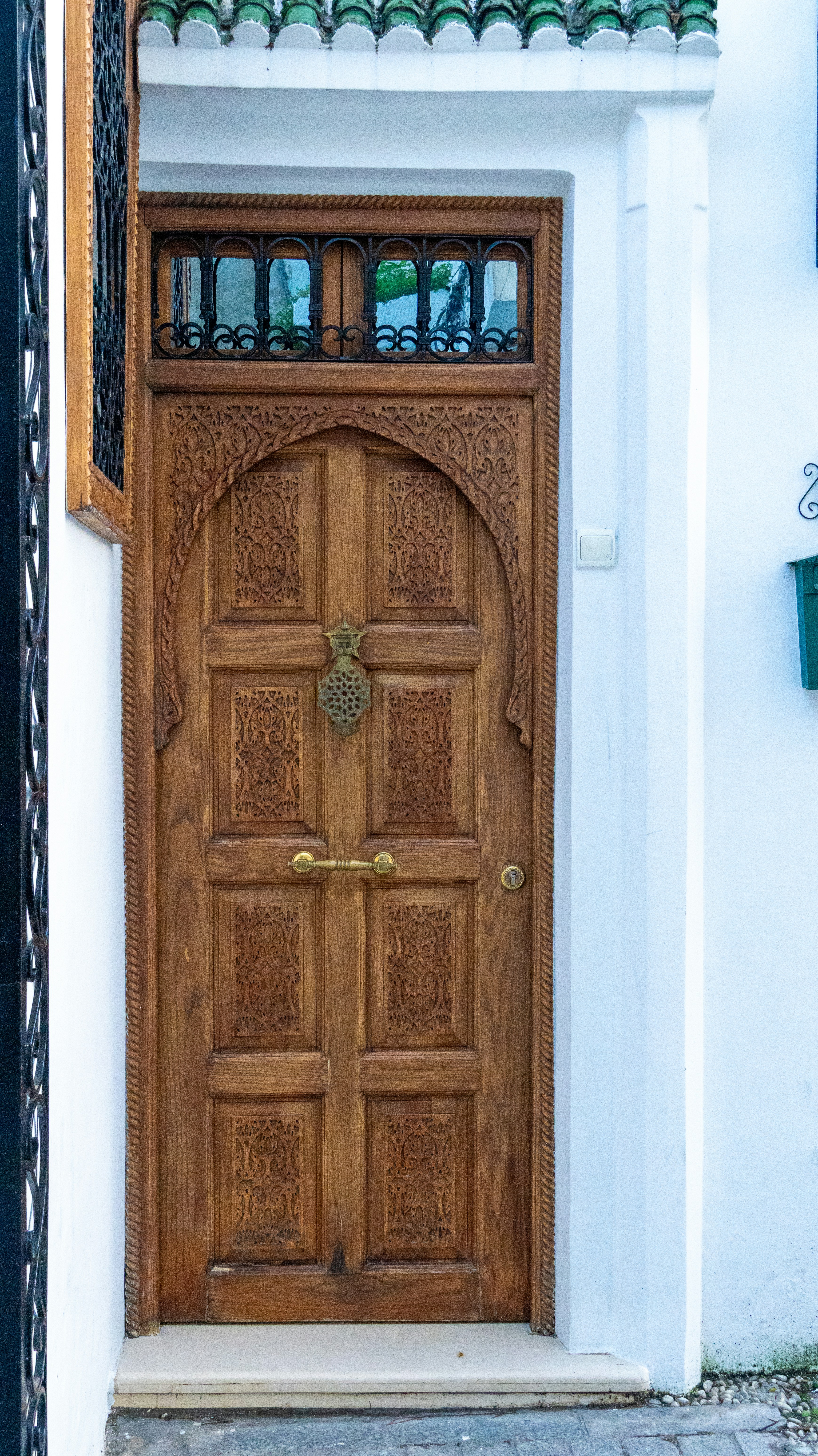 Intricately Carved Wooden Door Framed by White Archway