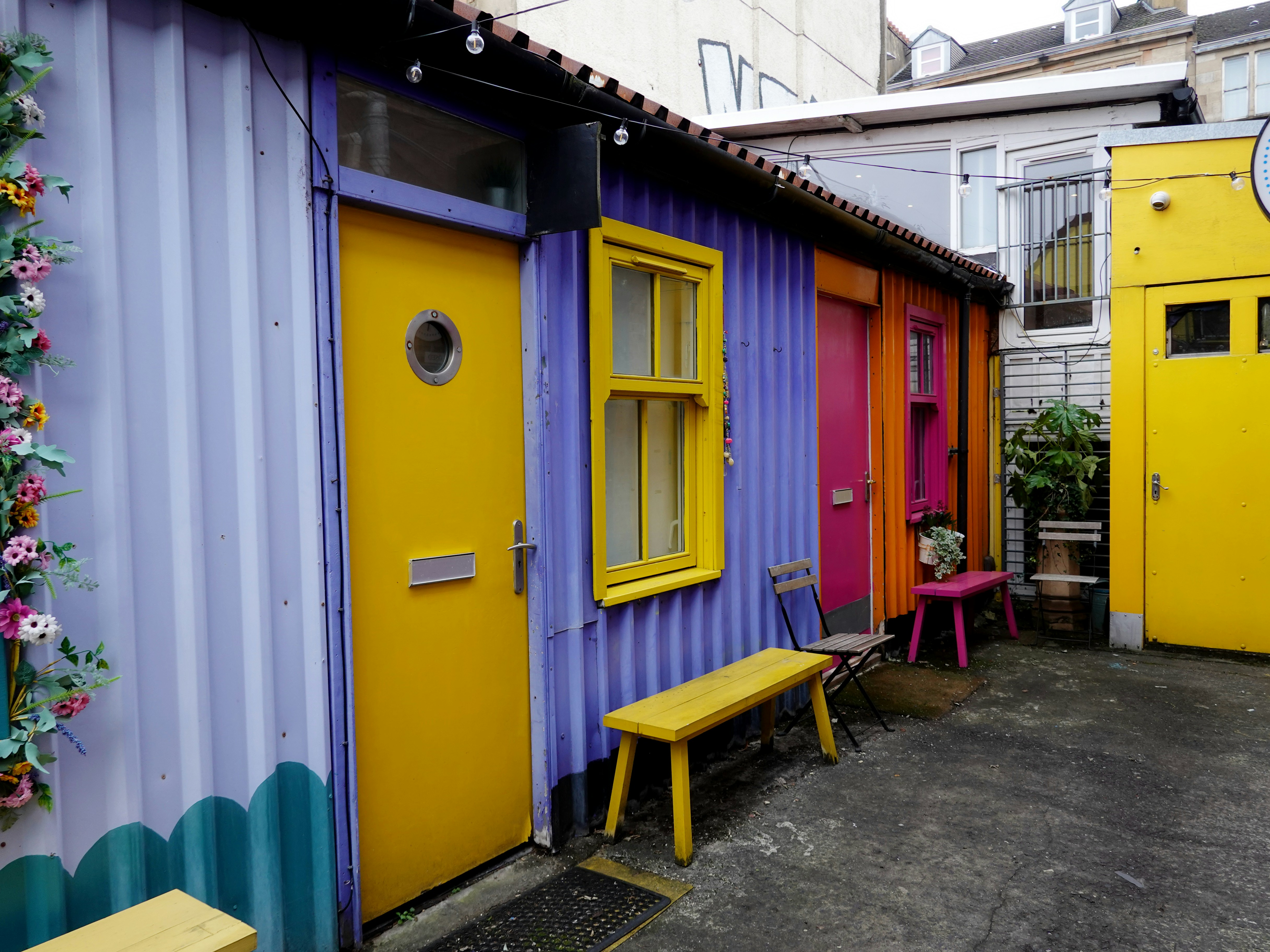 Colorful Candid Row: A Sunlit Alley of Painted Doors