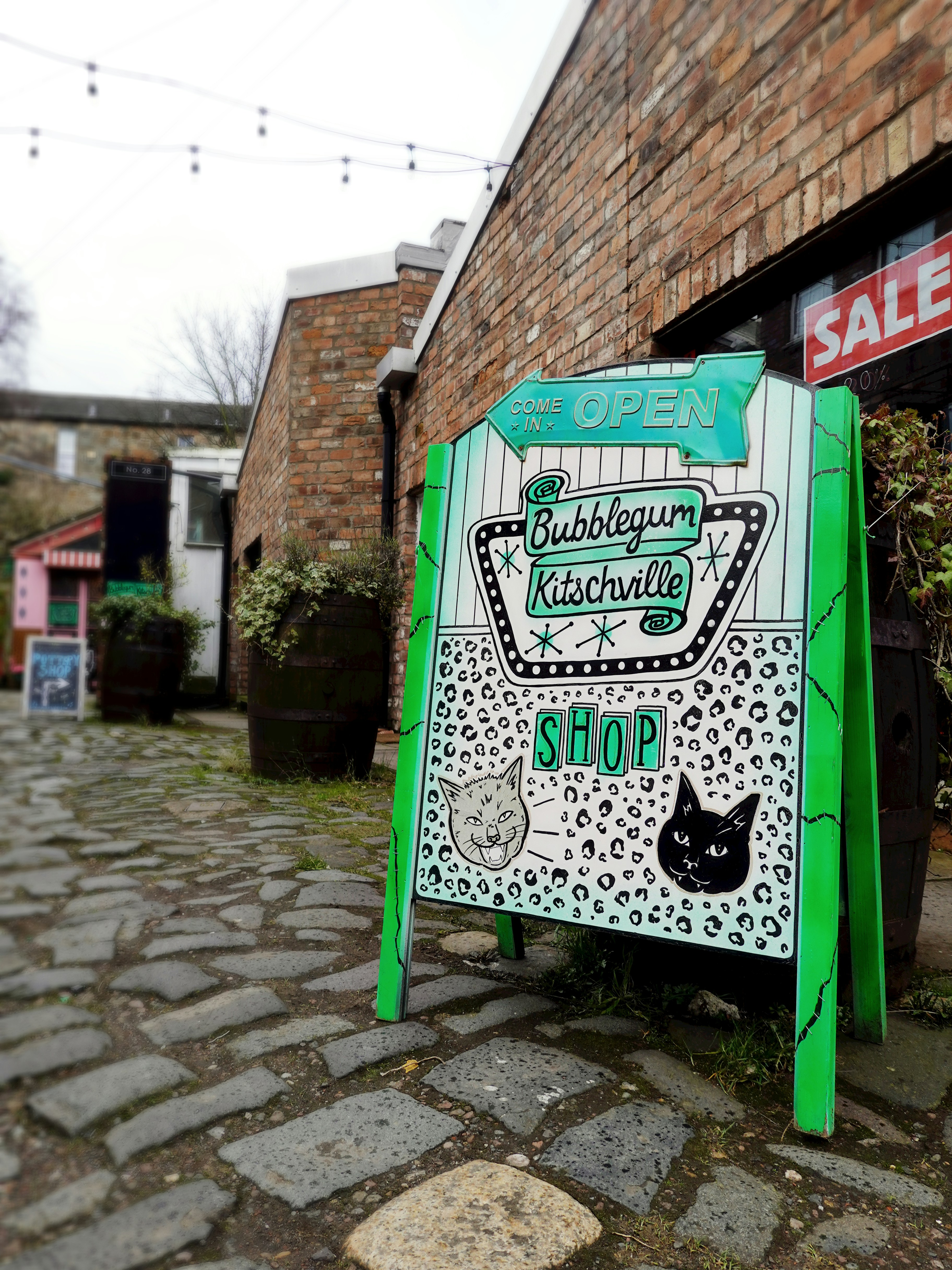 Vibrant Signboard in a Cobblestone Alley