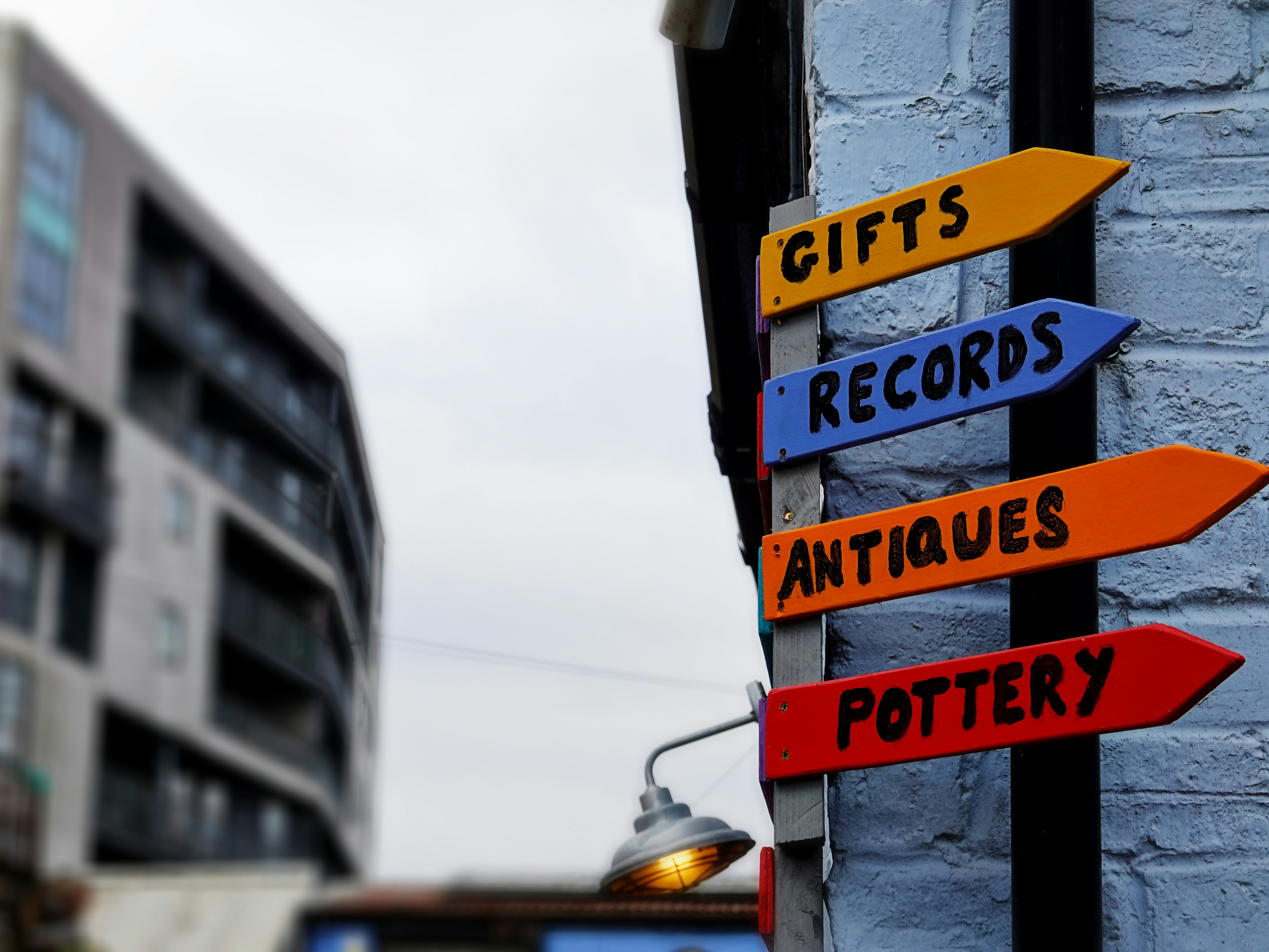 Colorful Signposts against a Blue Brick Wall