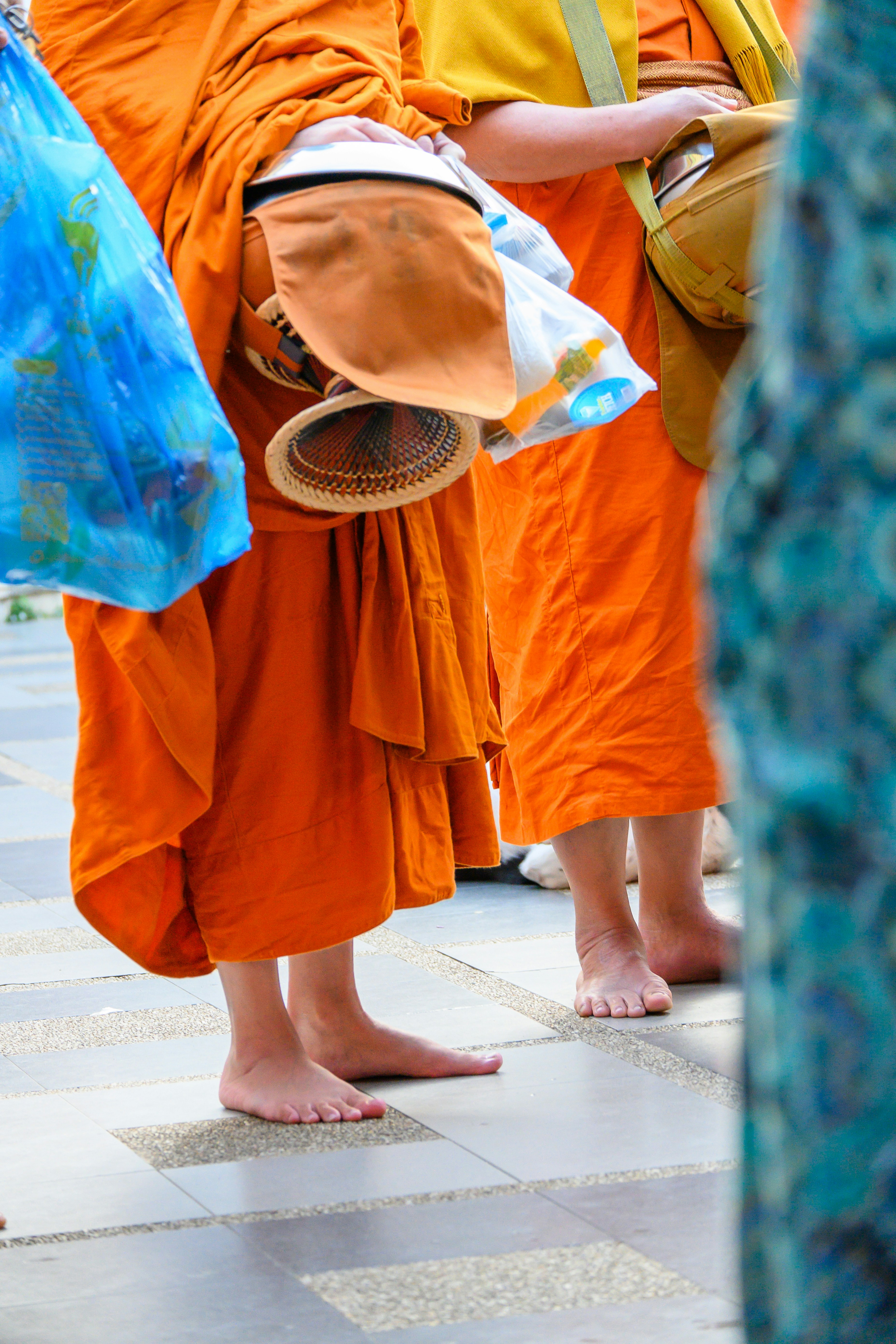 Bare feet, saffron robes, and a street-side stride: monks pause in motion