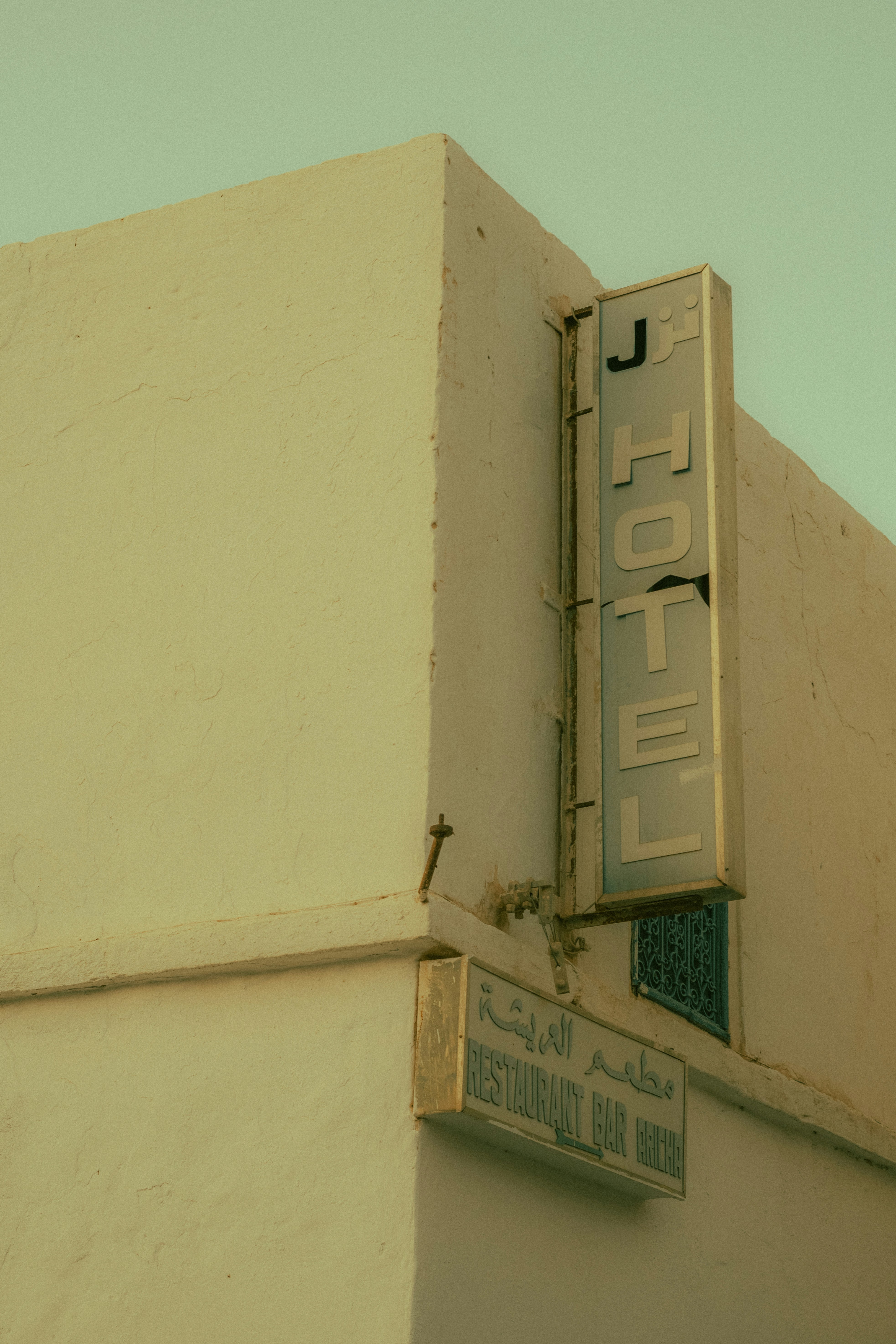 Mid-Century Motel Sign Casting Soft Shadows on Sand-Colored Walls