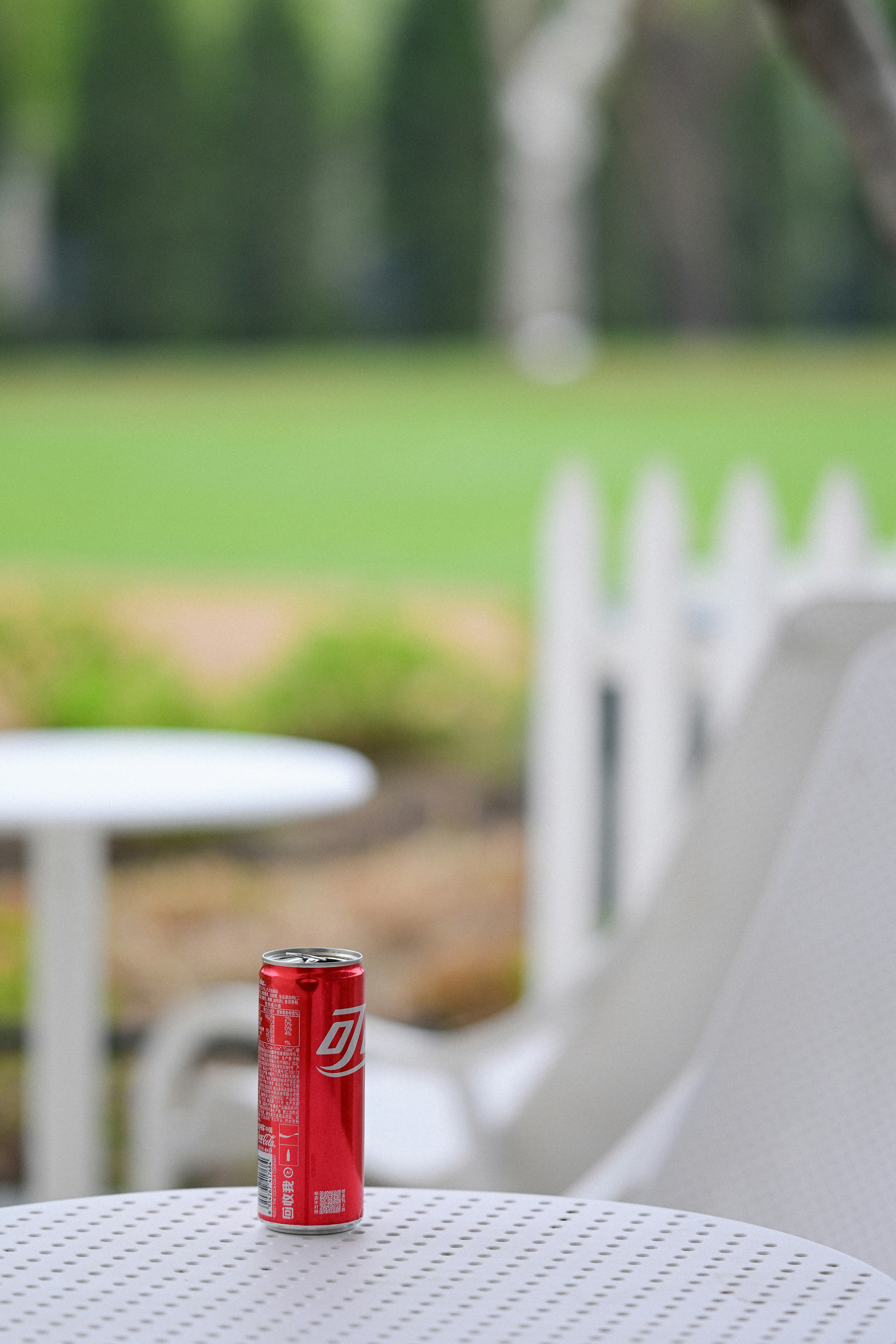 Red Can on Perforated Table Amid Quiet Outdoor Lounge