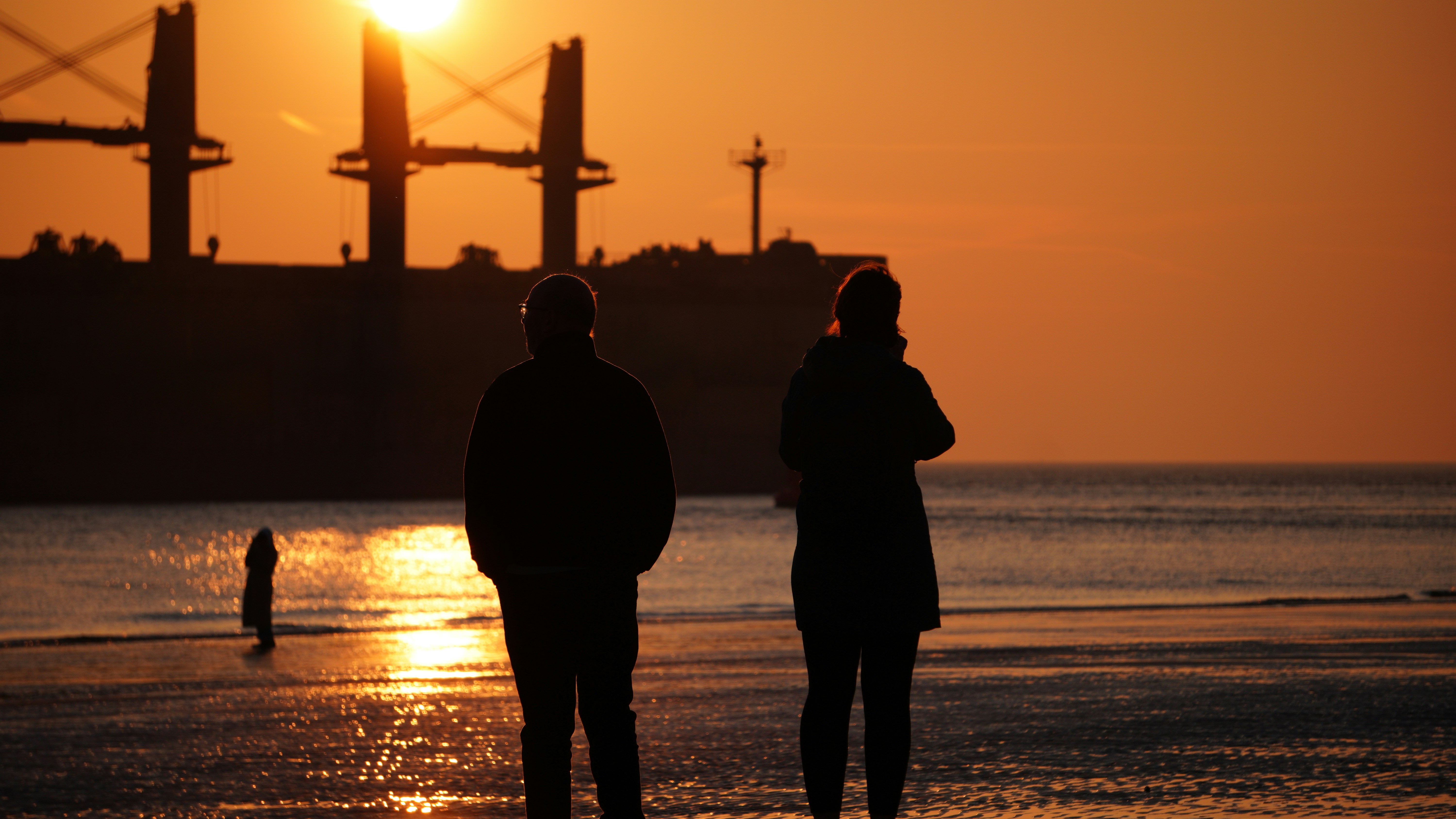 Two Silhouettes at Sunset: Quiet Harbor of Distant Work